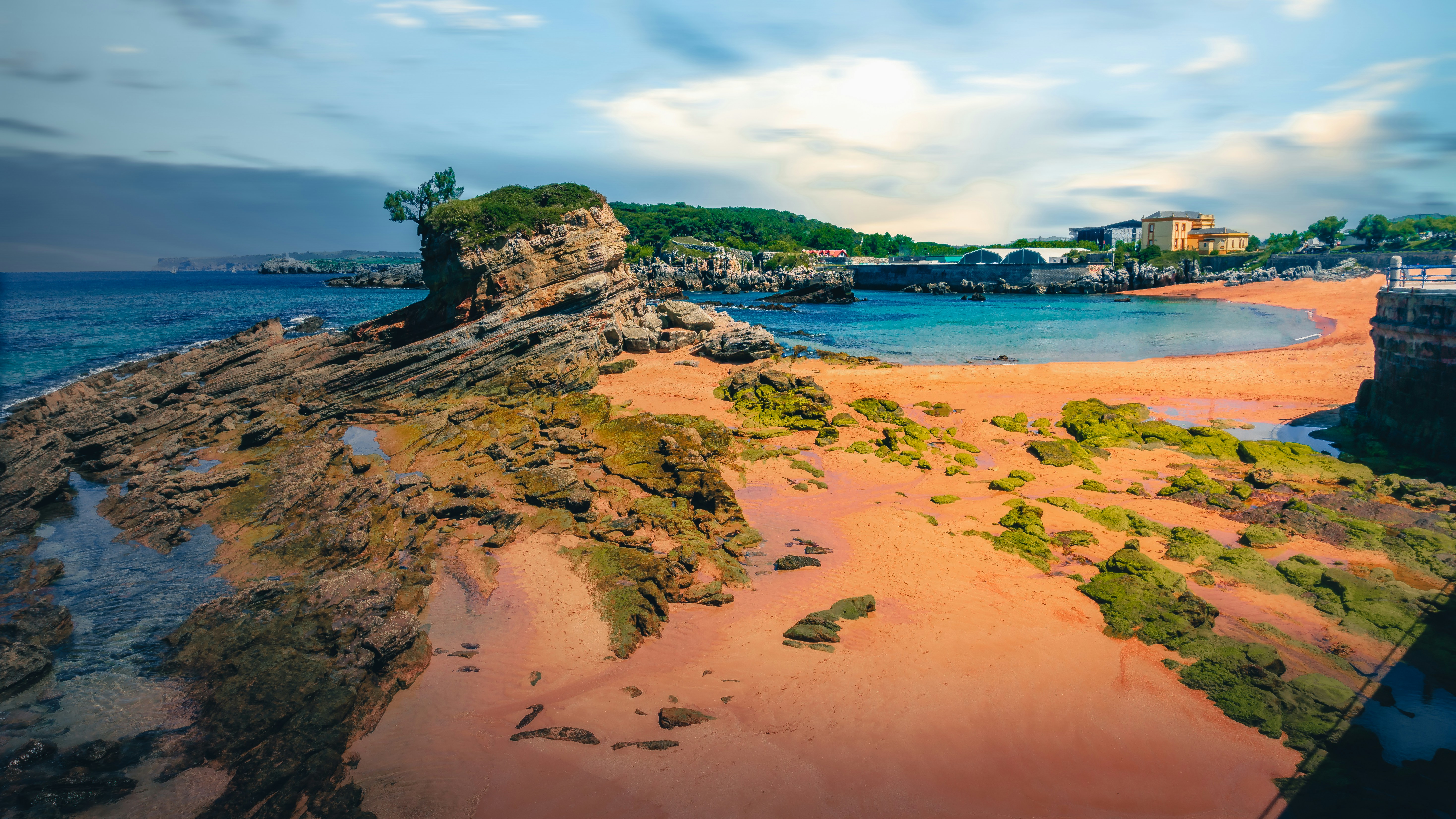 Sunlit Cliffscape: Terracotta Sands Meet Turquoise Tide