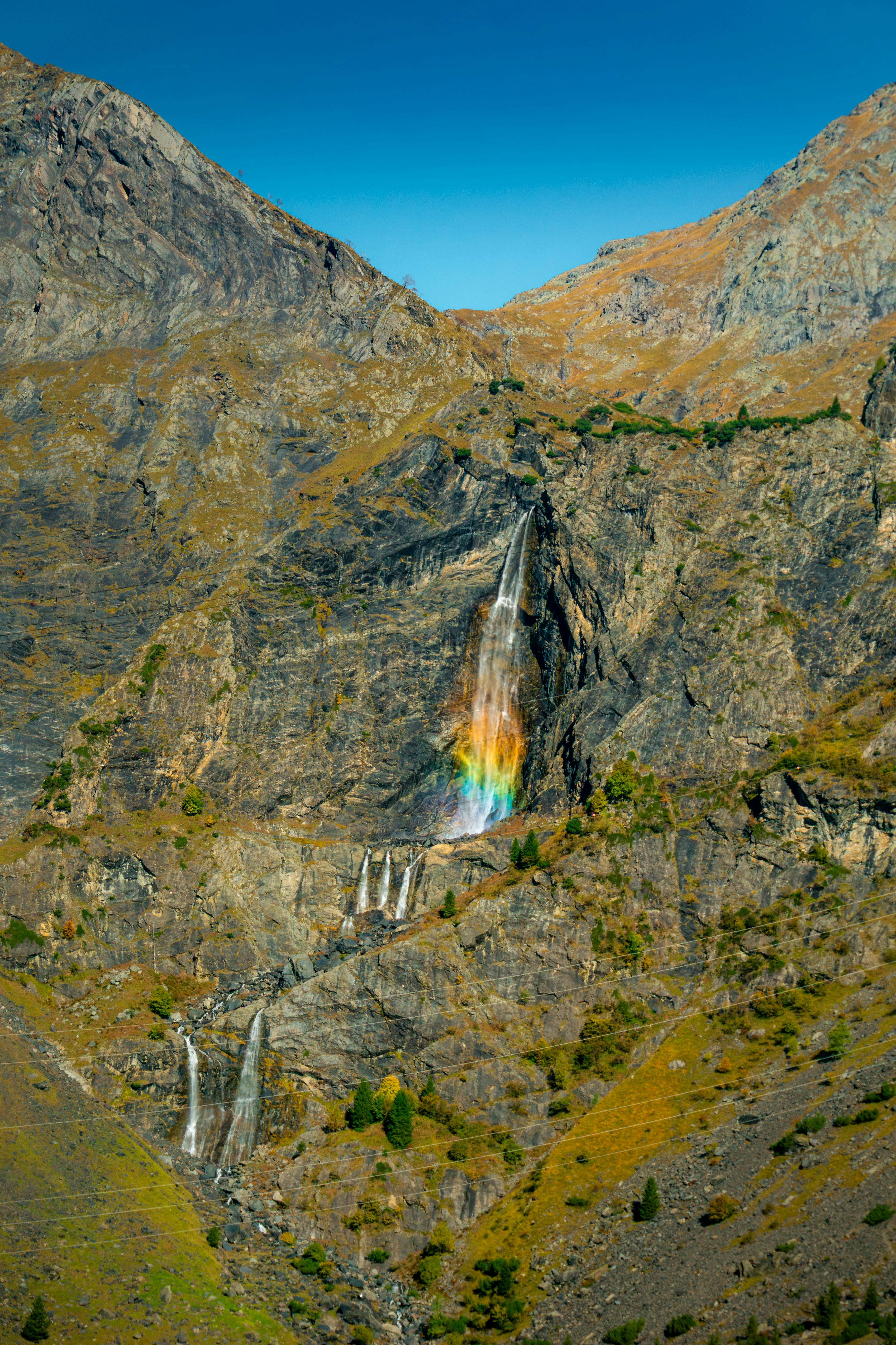 Rainbow Cascade Aglow Over Alpine Ruins