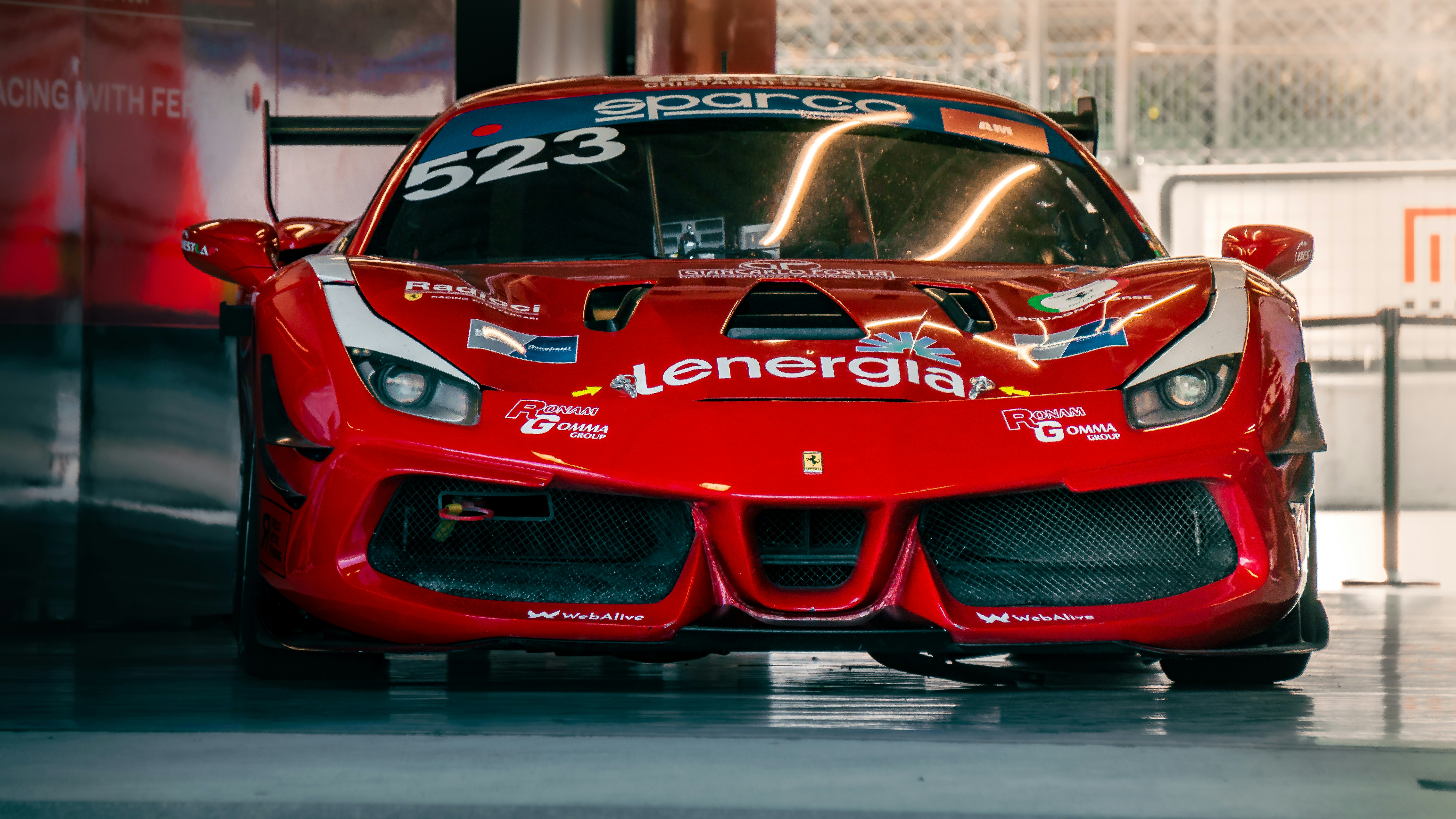 Red Racer in the Spotlight: Front View of a LenzGine Ferrari in the Pit