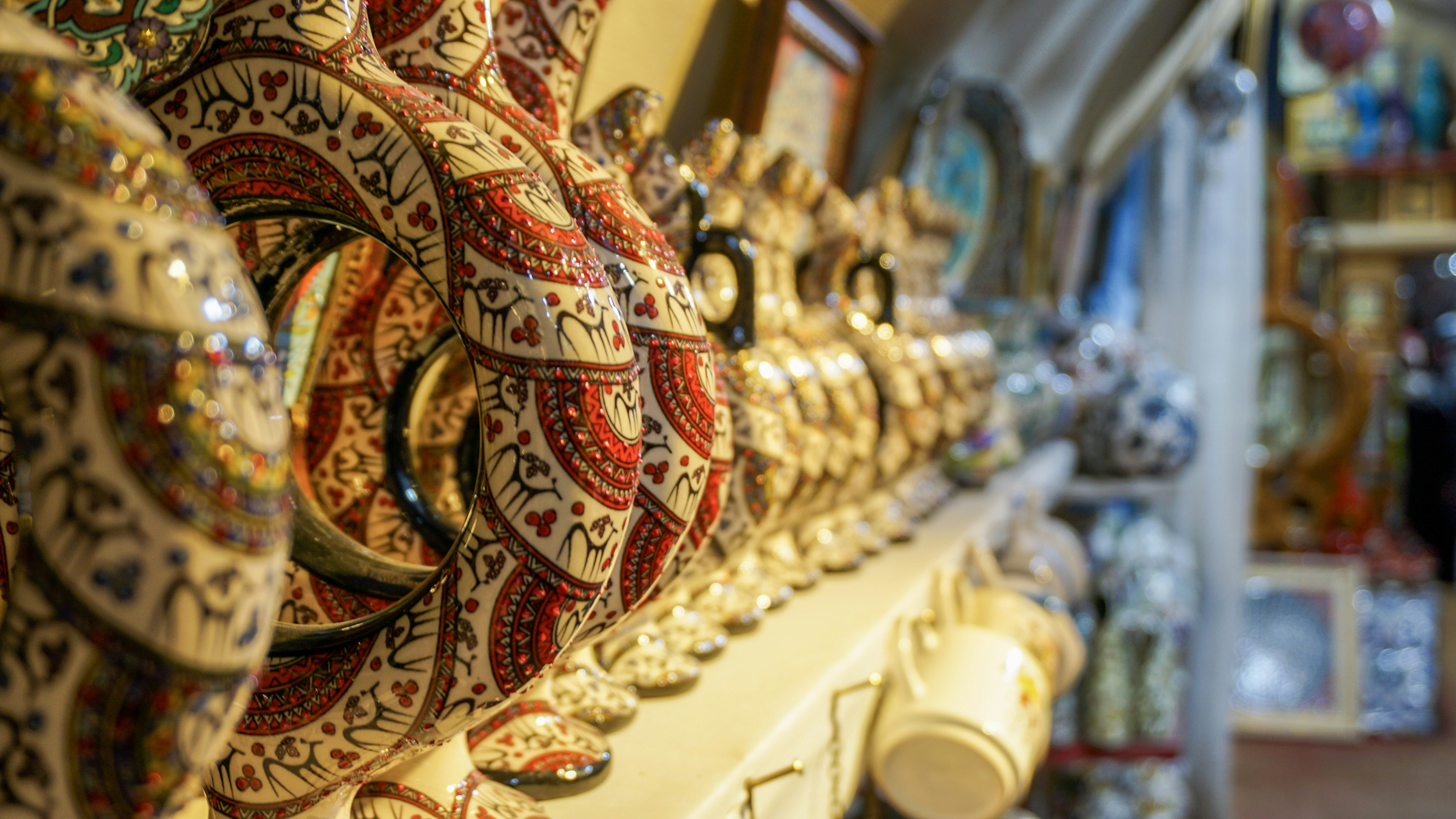 Row of Ornate Ceramic Jug Tops in a Market Display