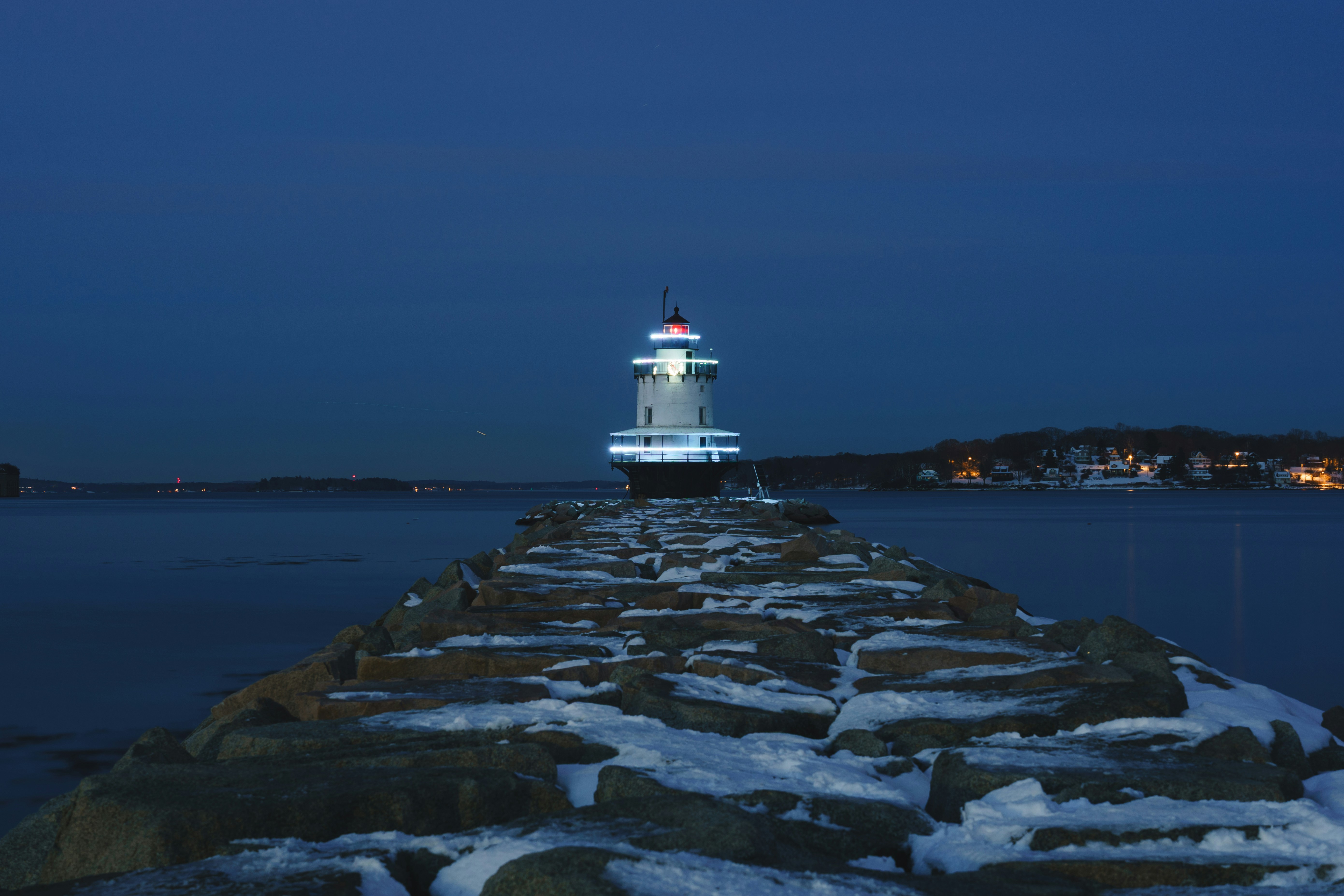 Lighthouse at the end of a snowy stone jetty photo – Free Winter Image ...