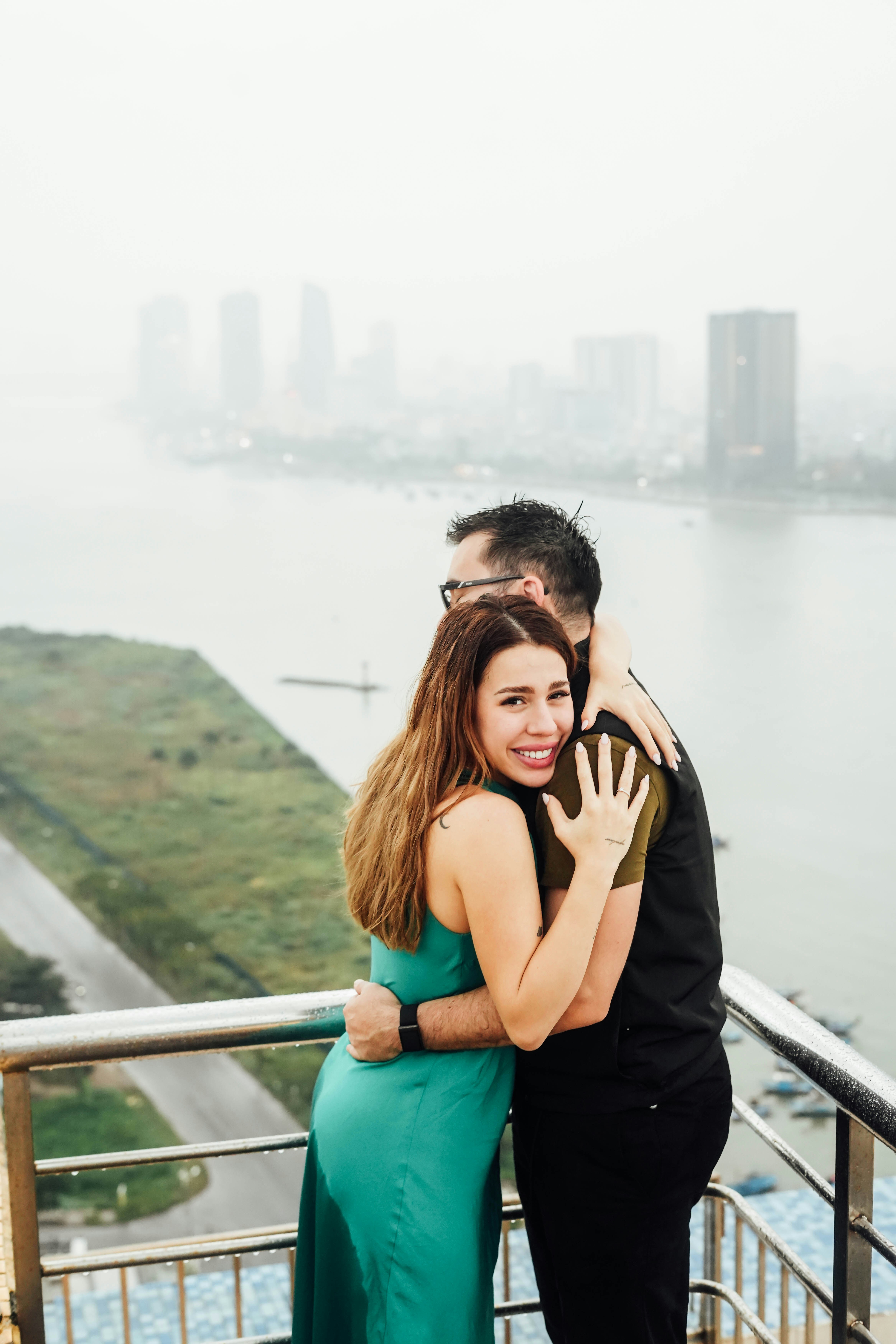 Embrace on the Waterfront: A Quiet Moment Above the River