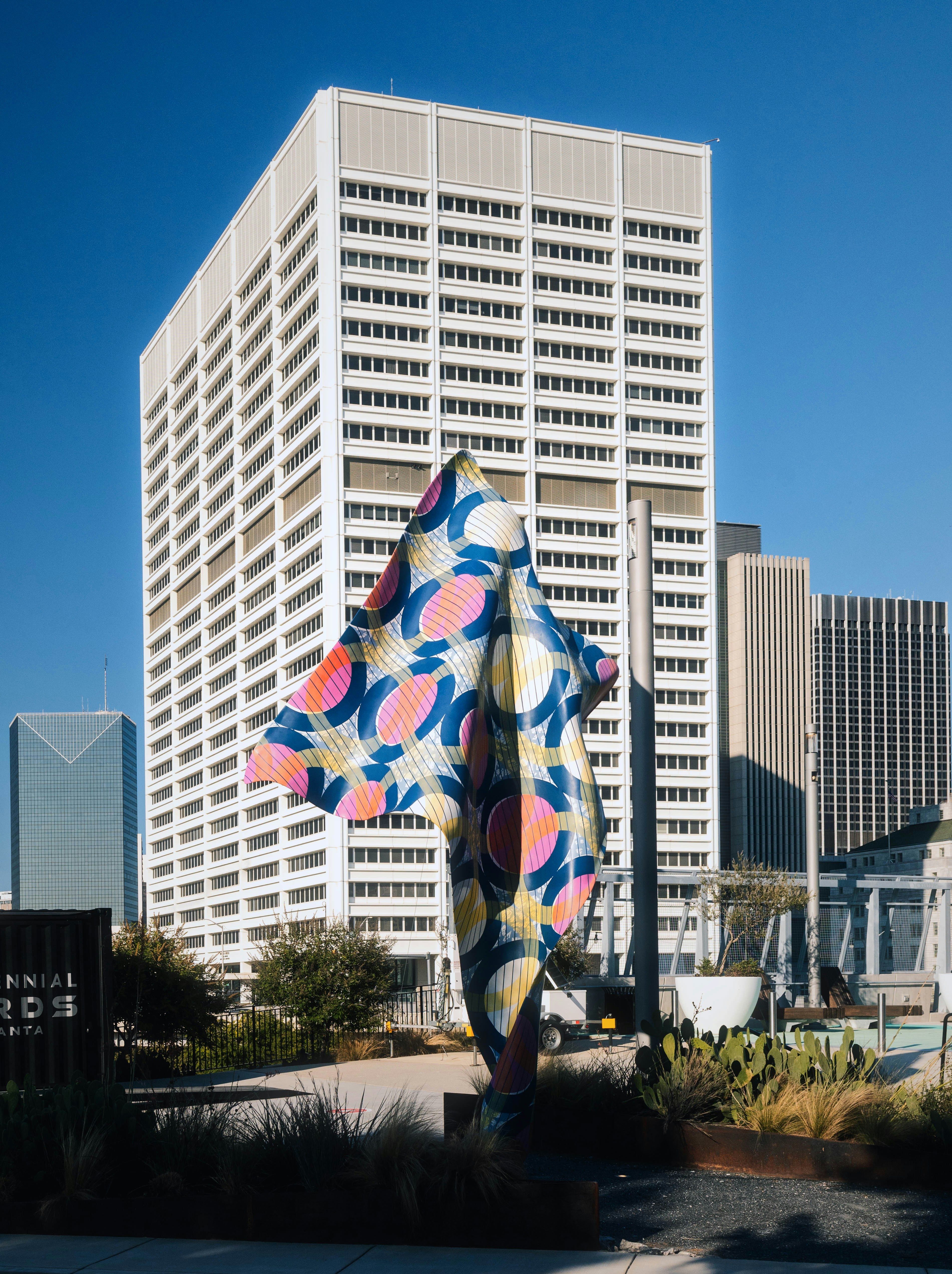 Colorful parasol sculpture anchors a city plaza
