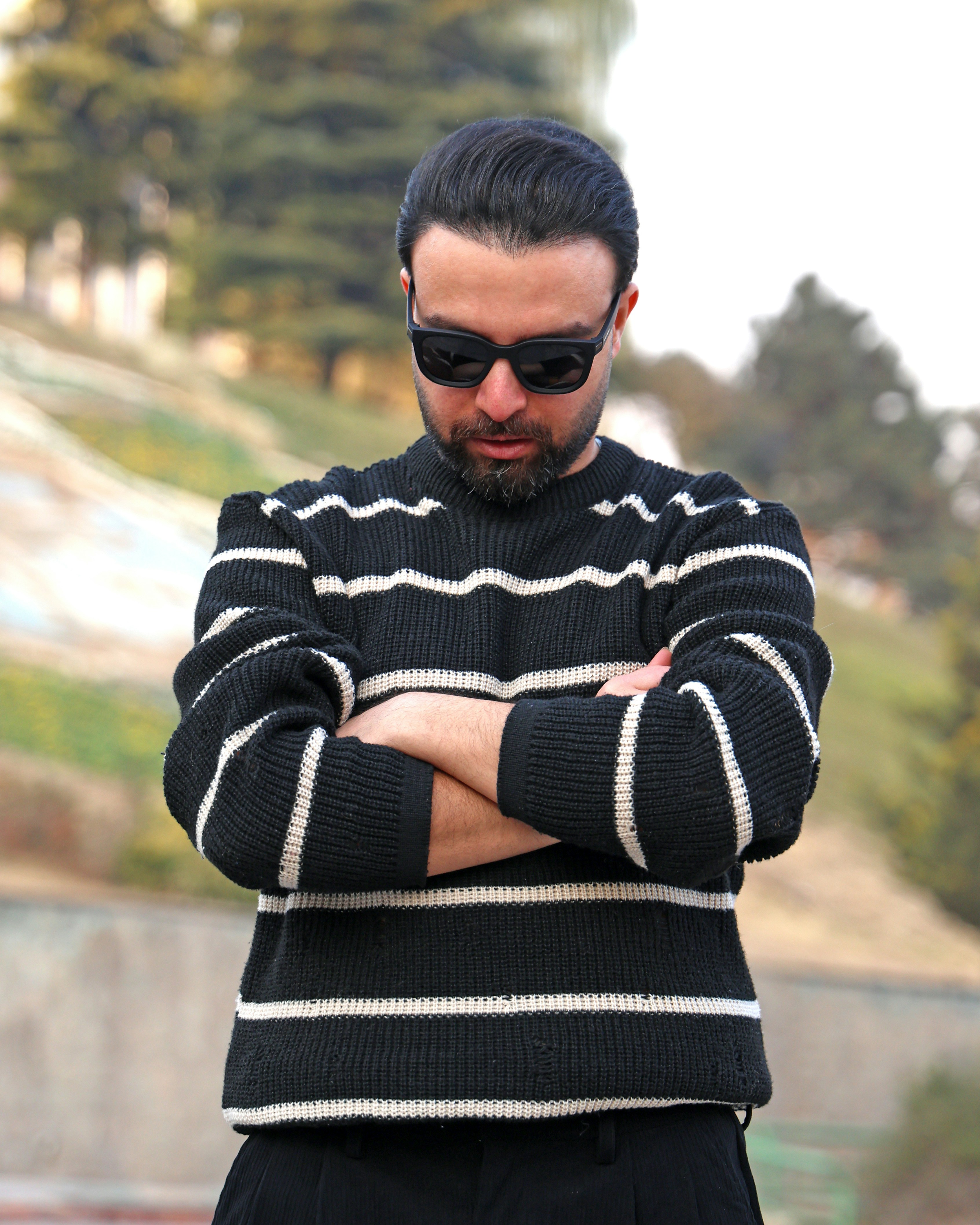 Crossed Arms, Quiet Intensity: A Portrait in Striped Knit