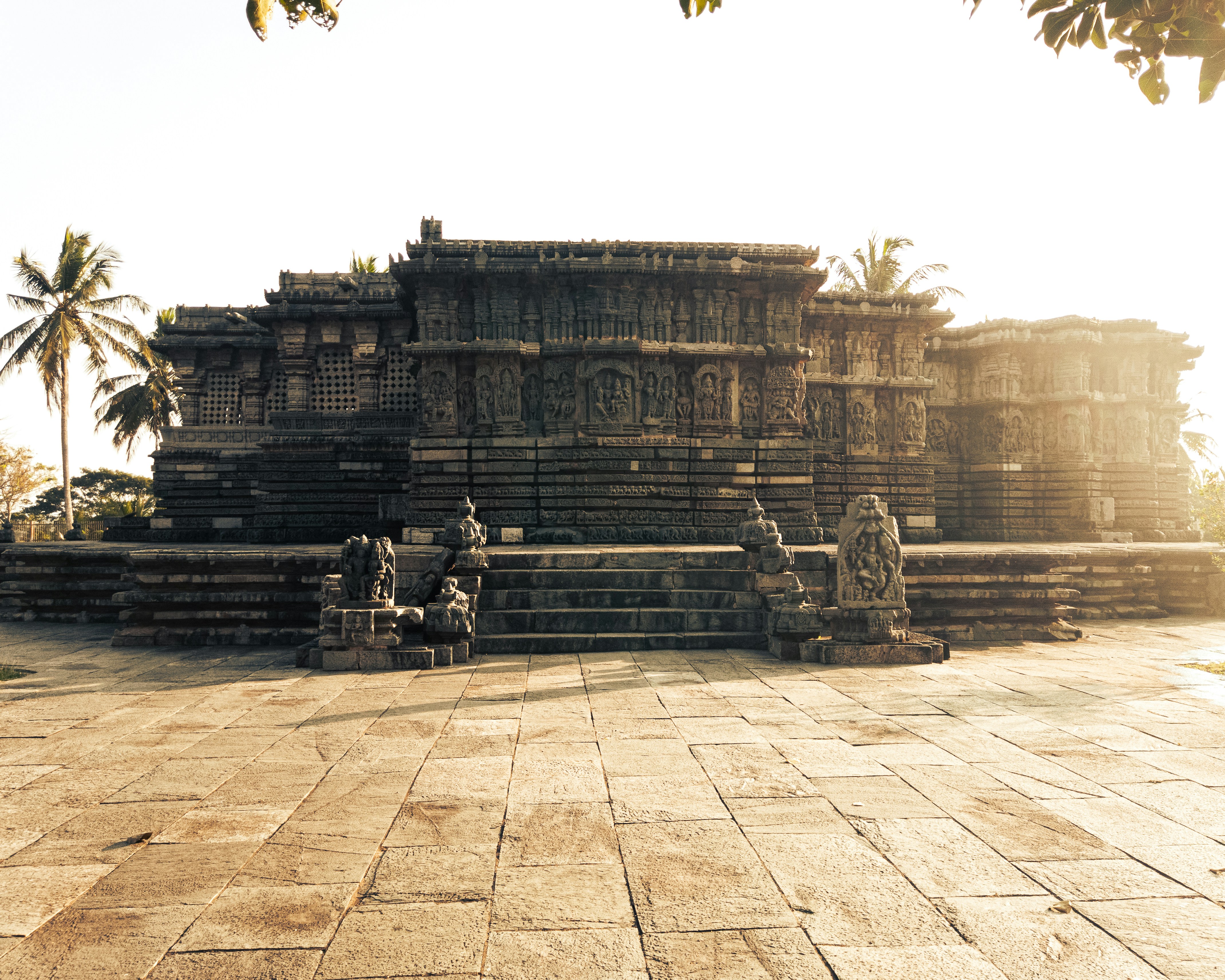 Ancient stone temple with intricate carvings and palm trees.