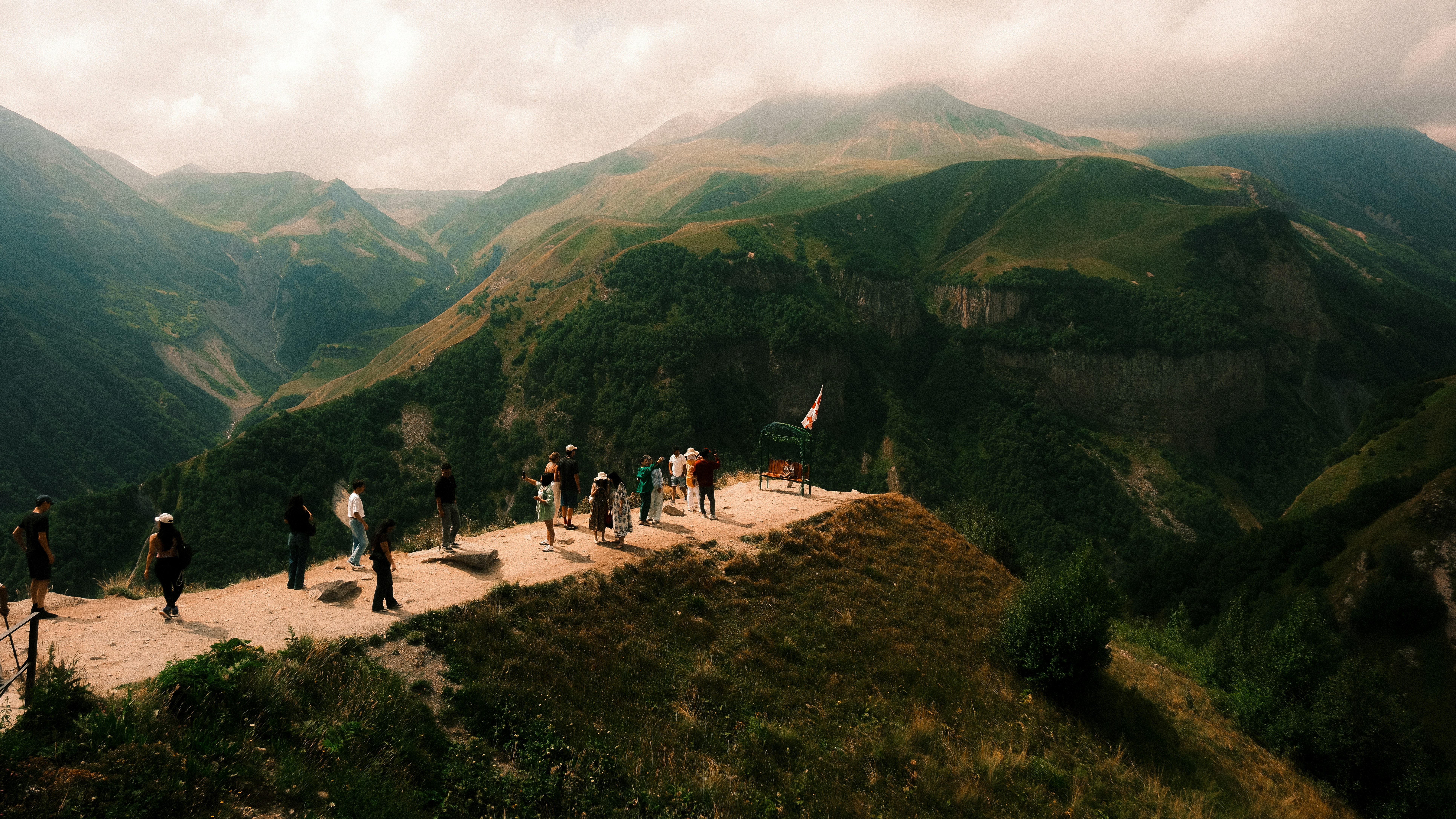 Hikers on a cliff edge: a panoramic ascent above misty valleys