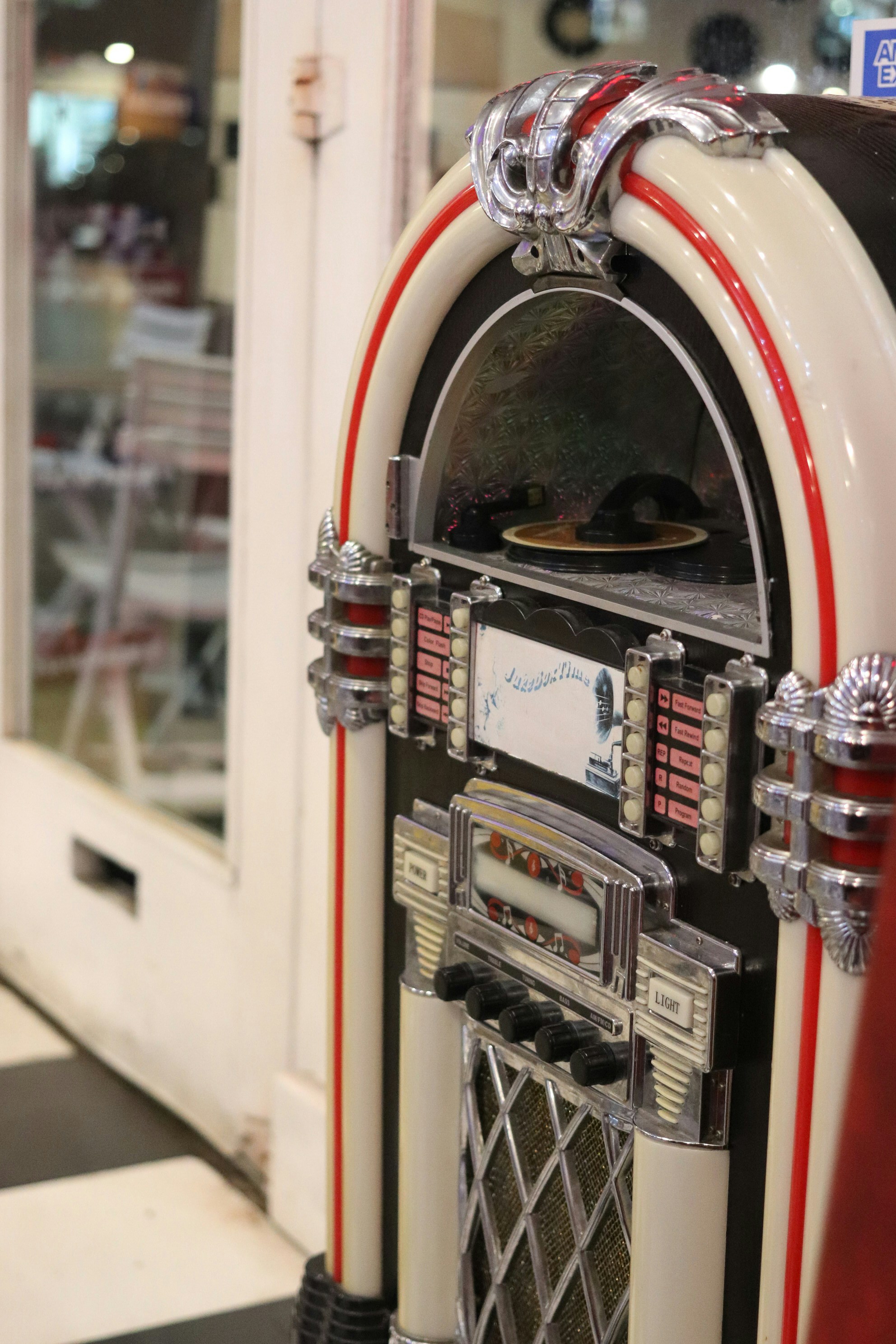 Neon Nostalgia: A Vintage Jukebox Stands Guard by the Café Window