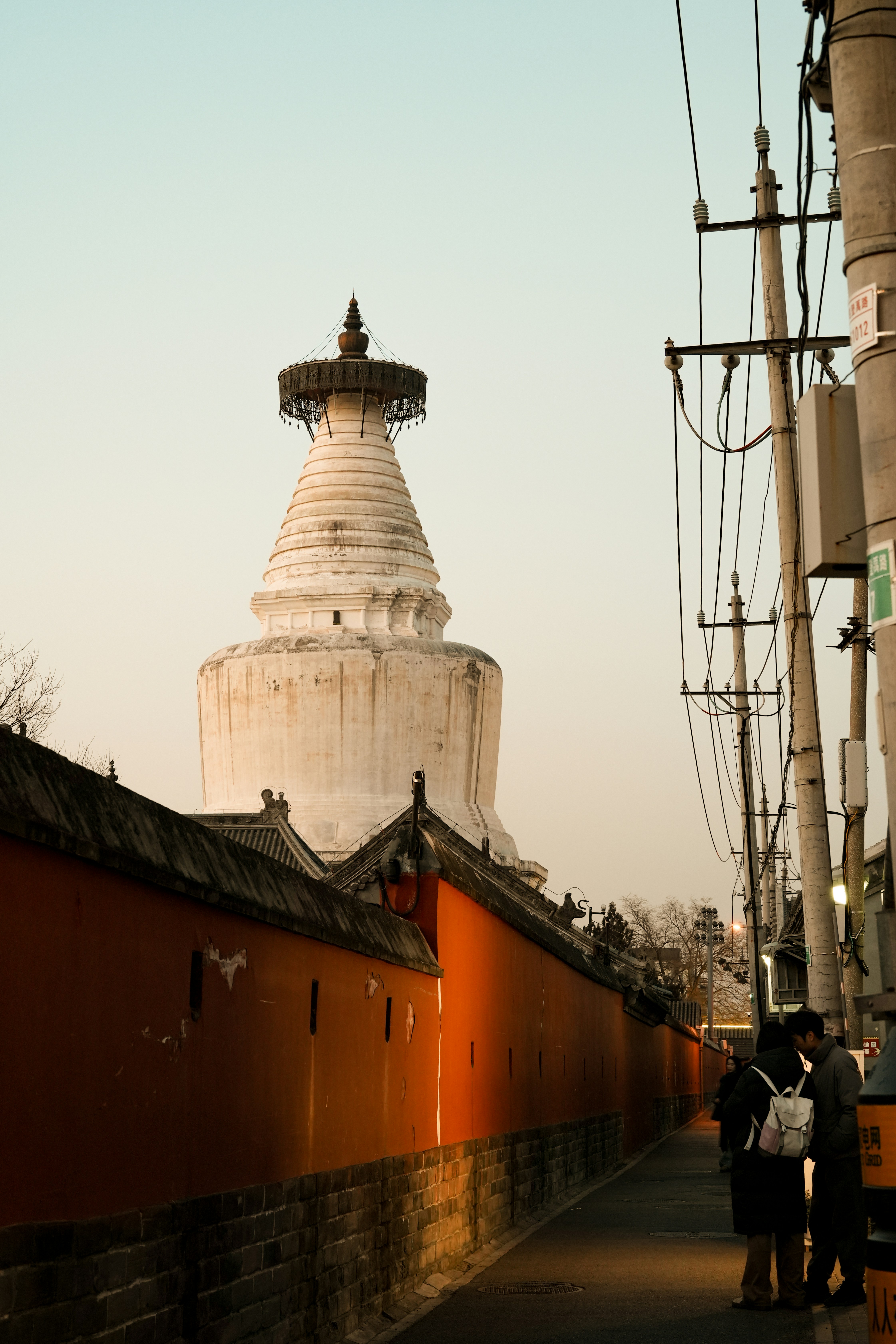 Hushed Temple silhouette along sunlit city wall
