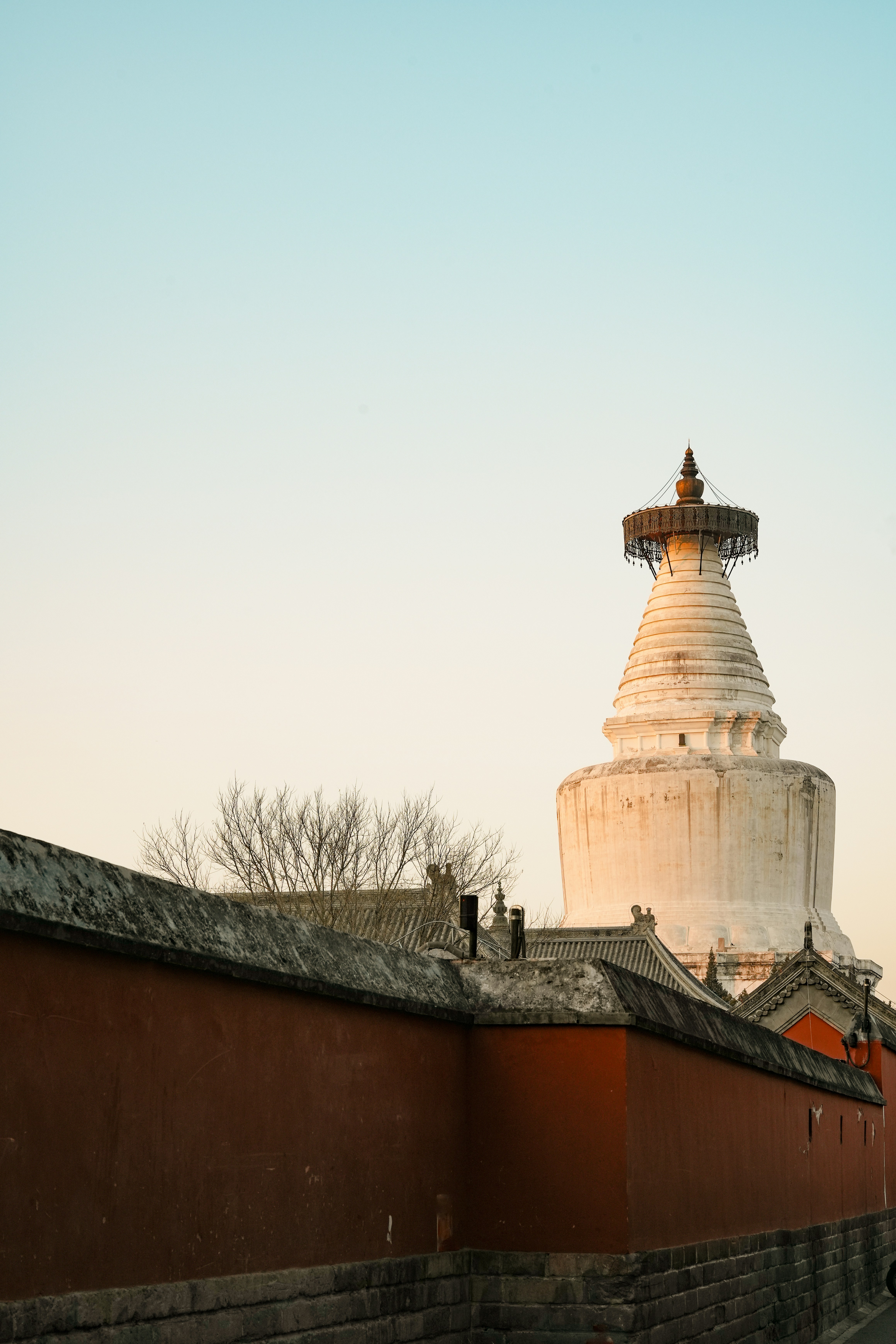 White Stupa Rising Over the City Wall at Dusk