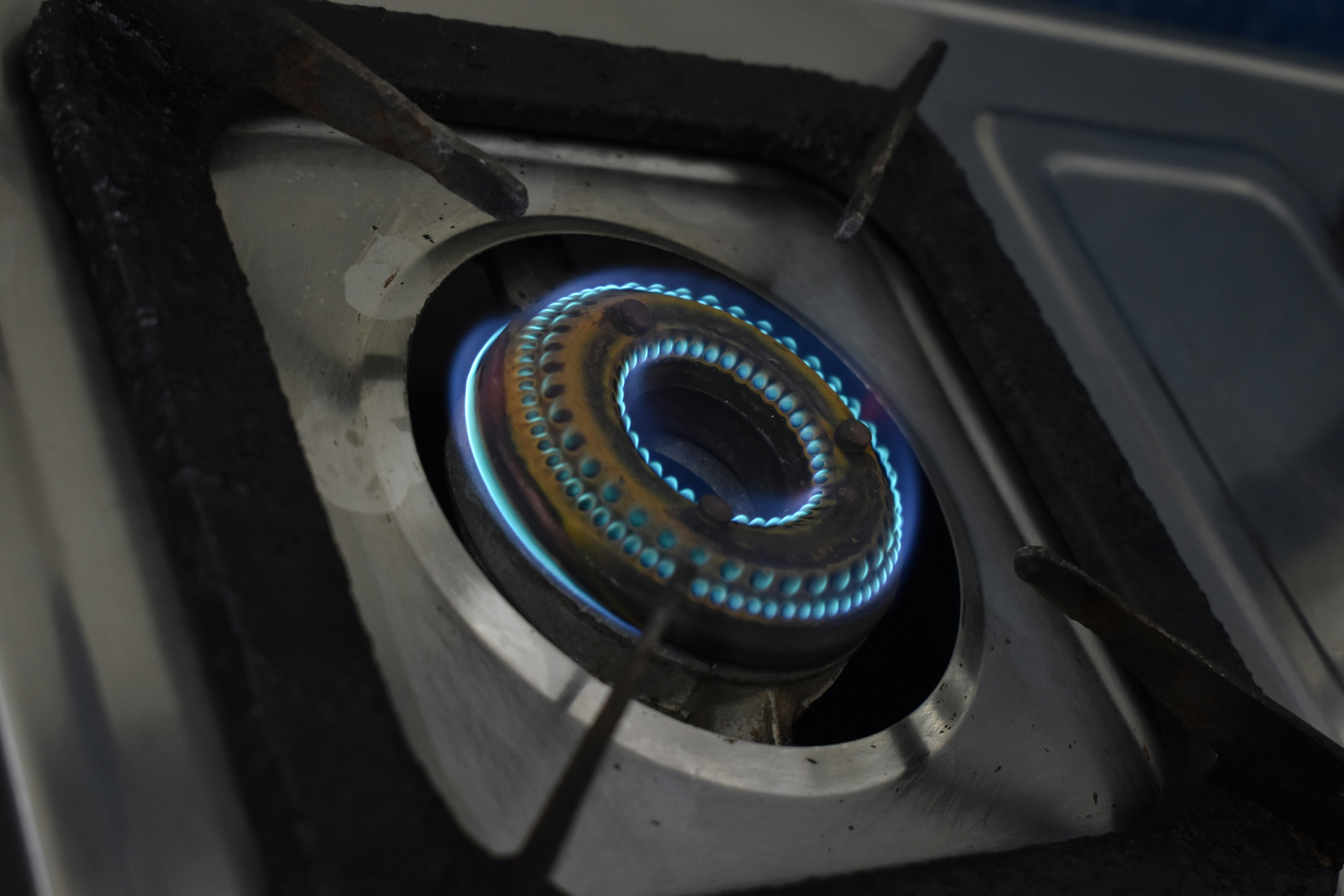 Blue-Hued Flame: Close-Up of a Gas Burner Ring in Focus