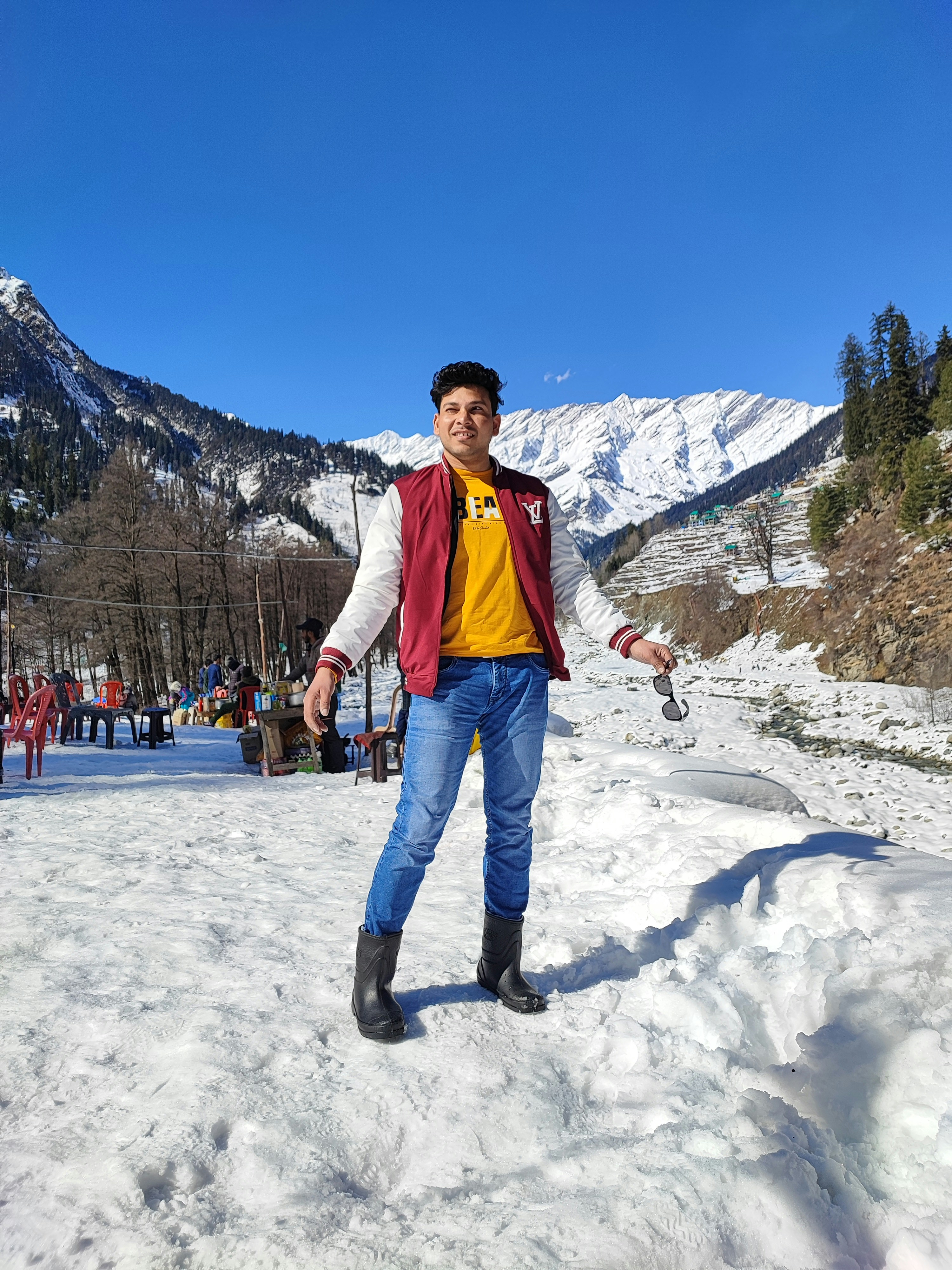 Young man in snow with mountains behind