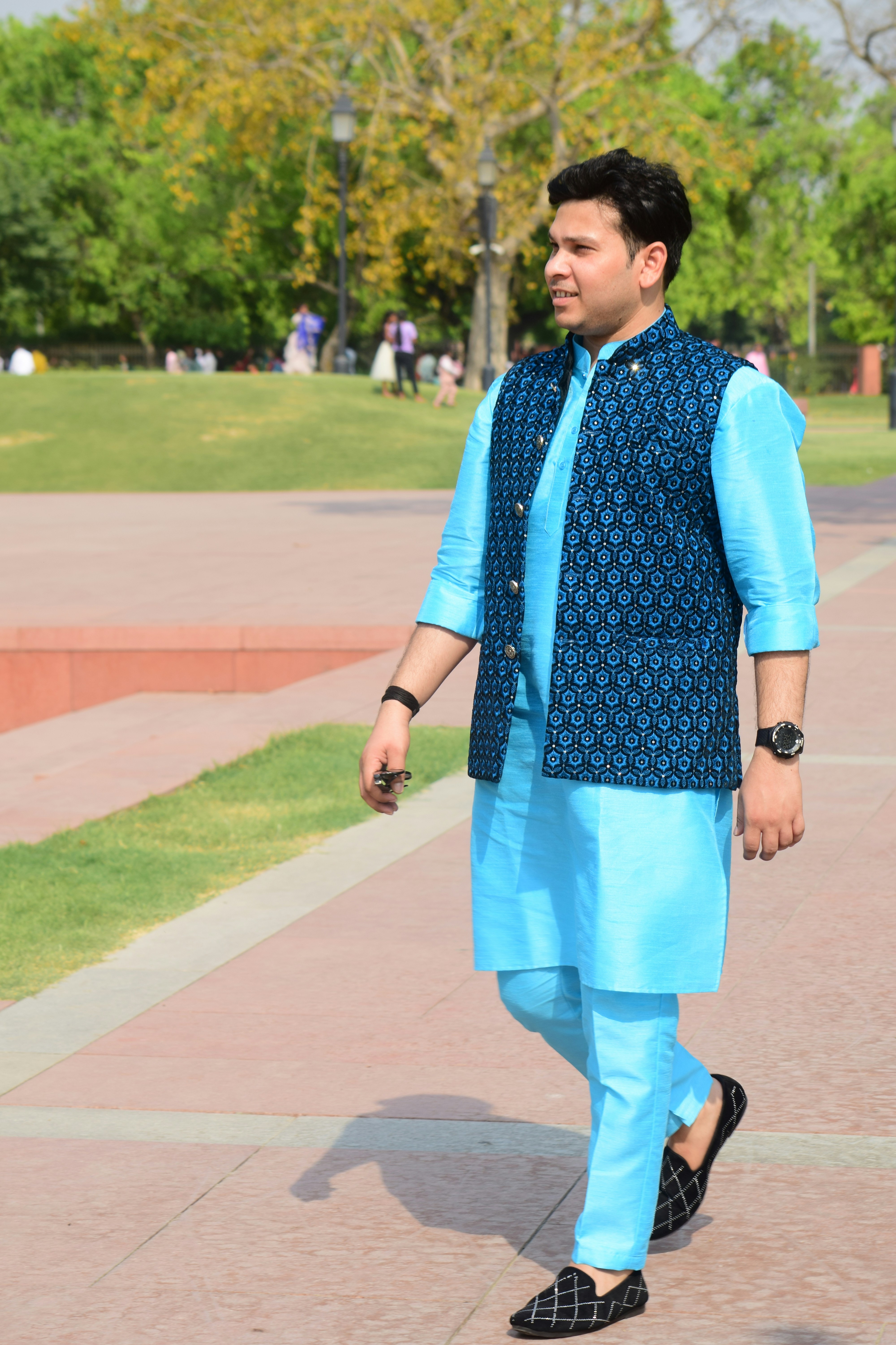Azure Attire in the Park: A Man Strolling in a Crafted Daylight Moment