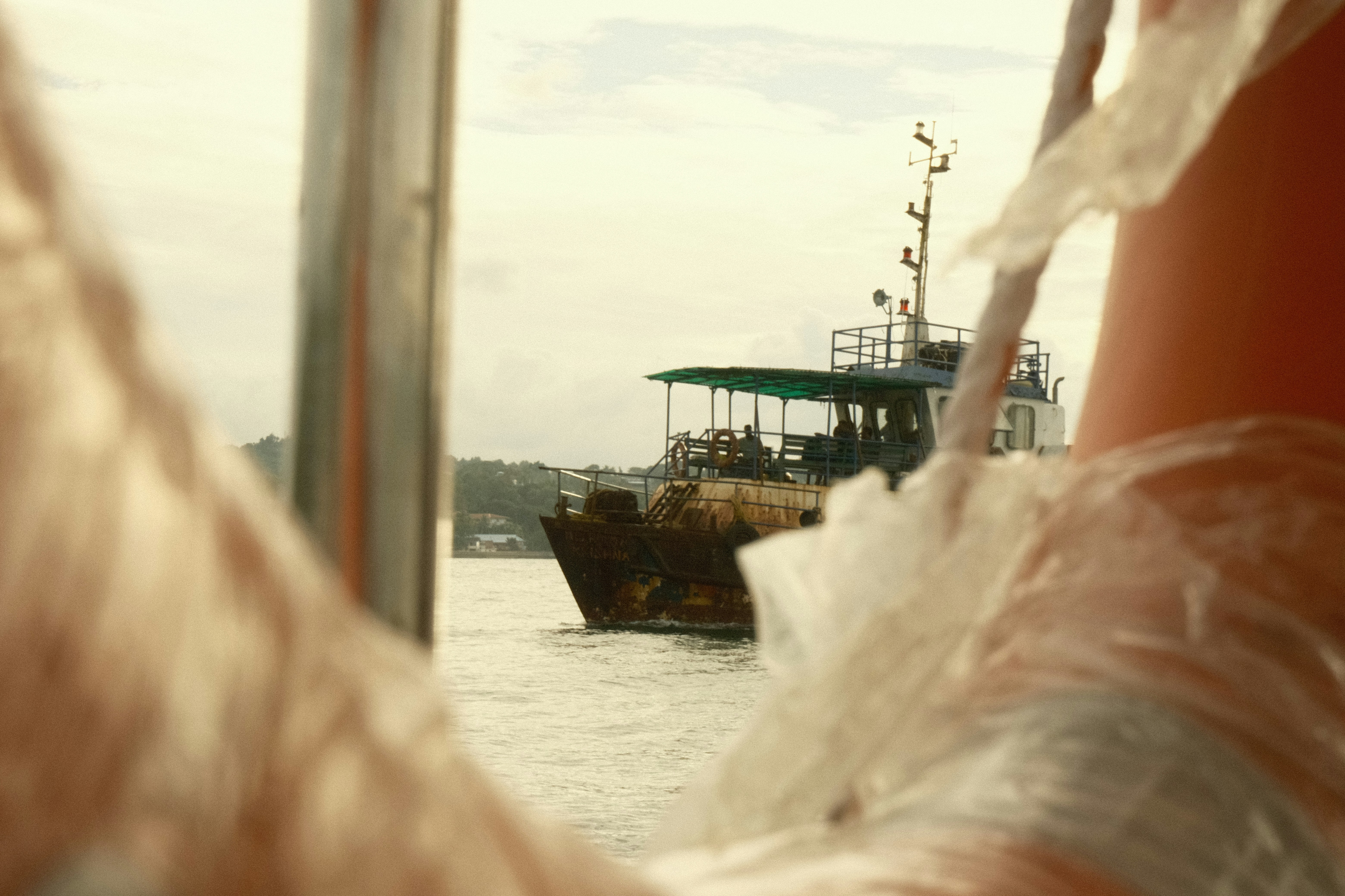 Through the Curtain: A Ferry Boat Advancing Beyond Plastic Sheen