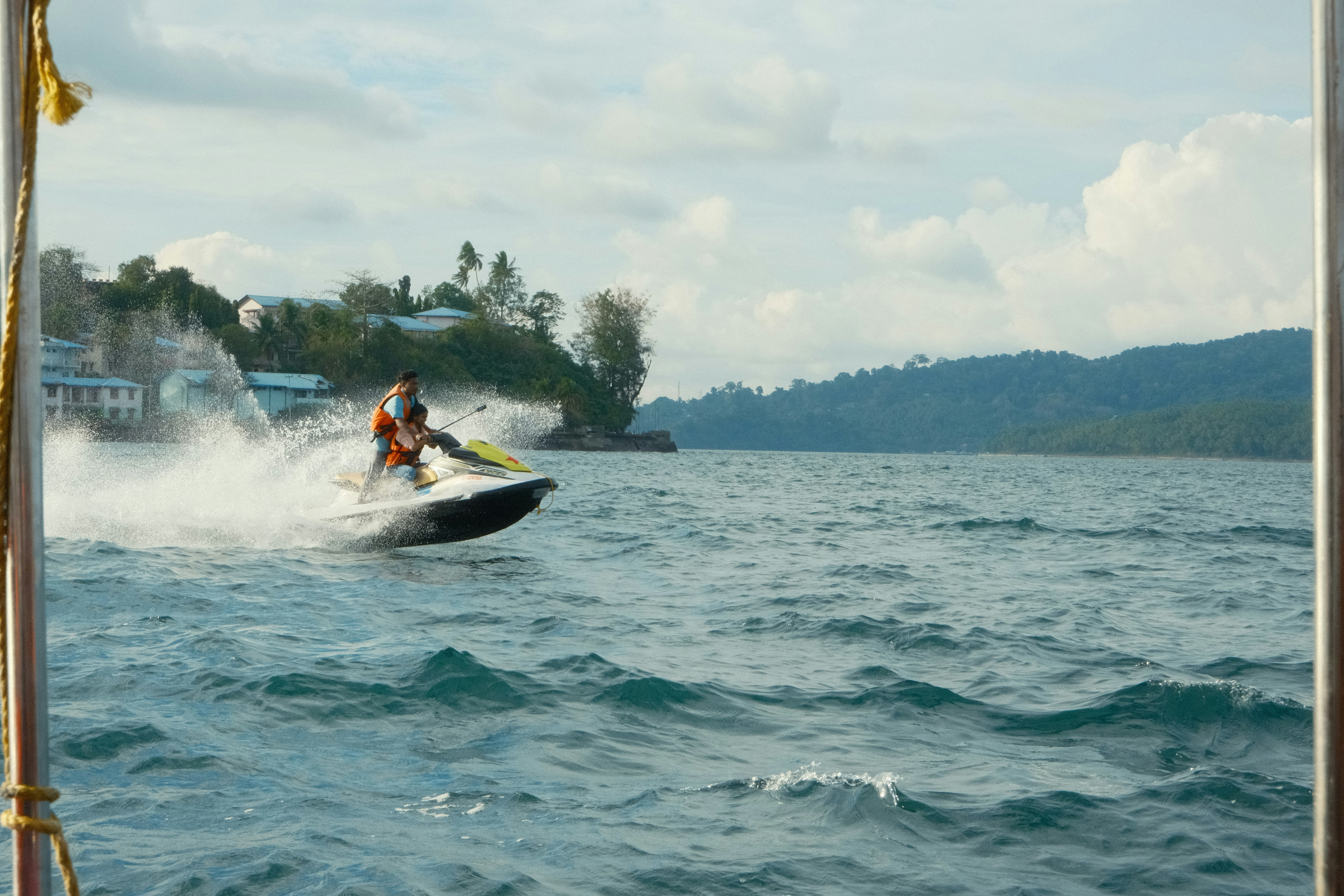 Jet-skiing silhouette: A lone rider carving a spray along coastal blue