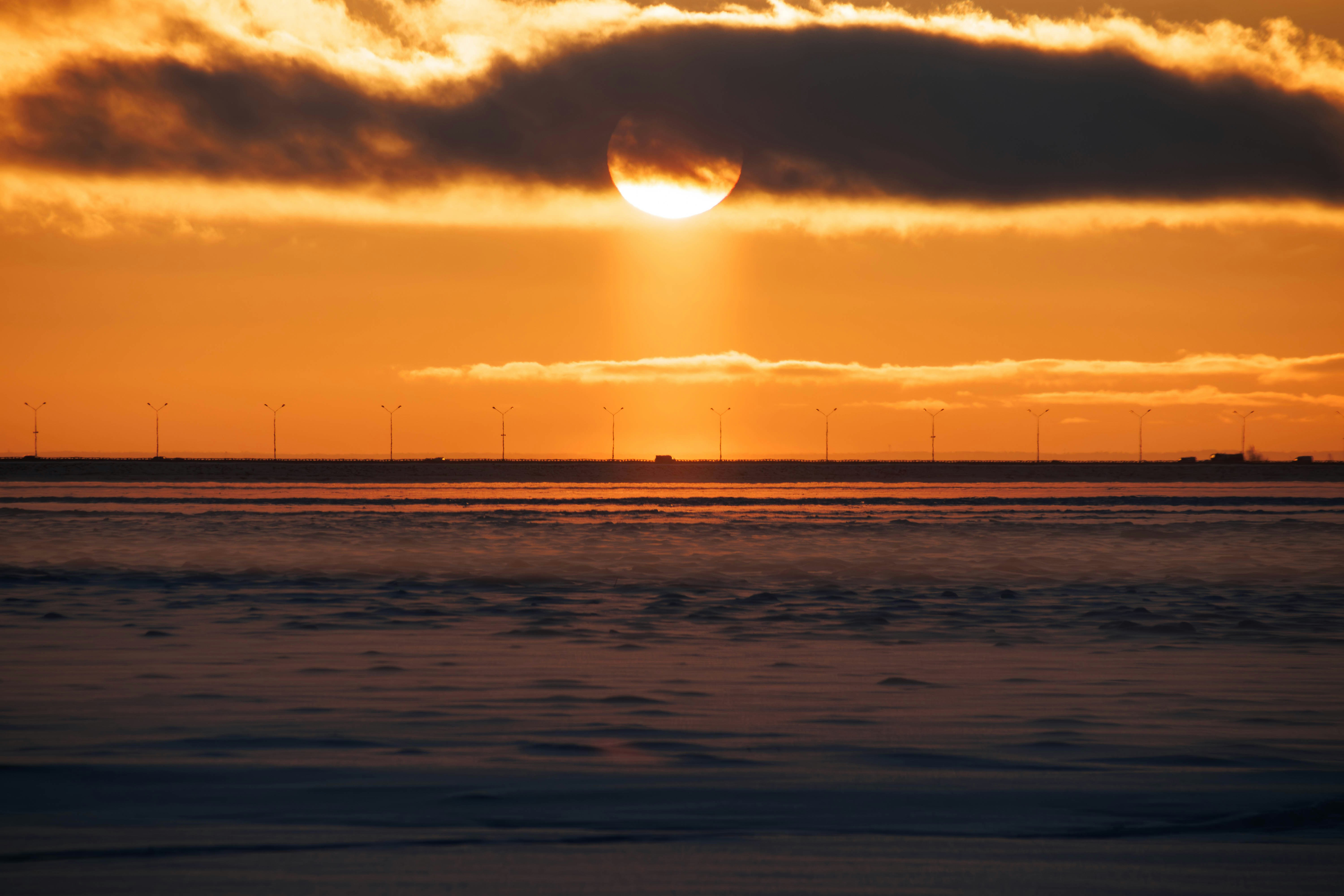 Partial Solar Halo at Sunset Over a Calm Coastal Line