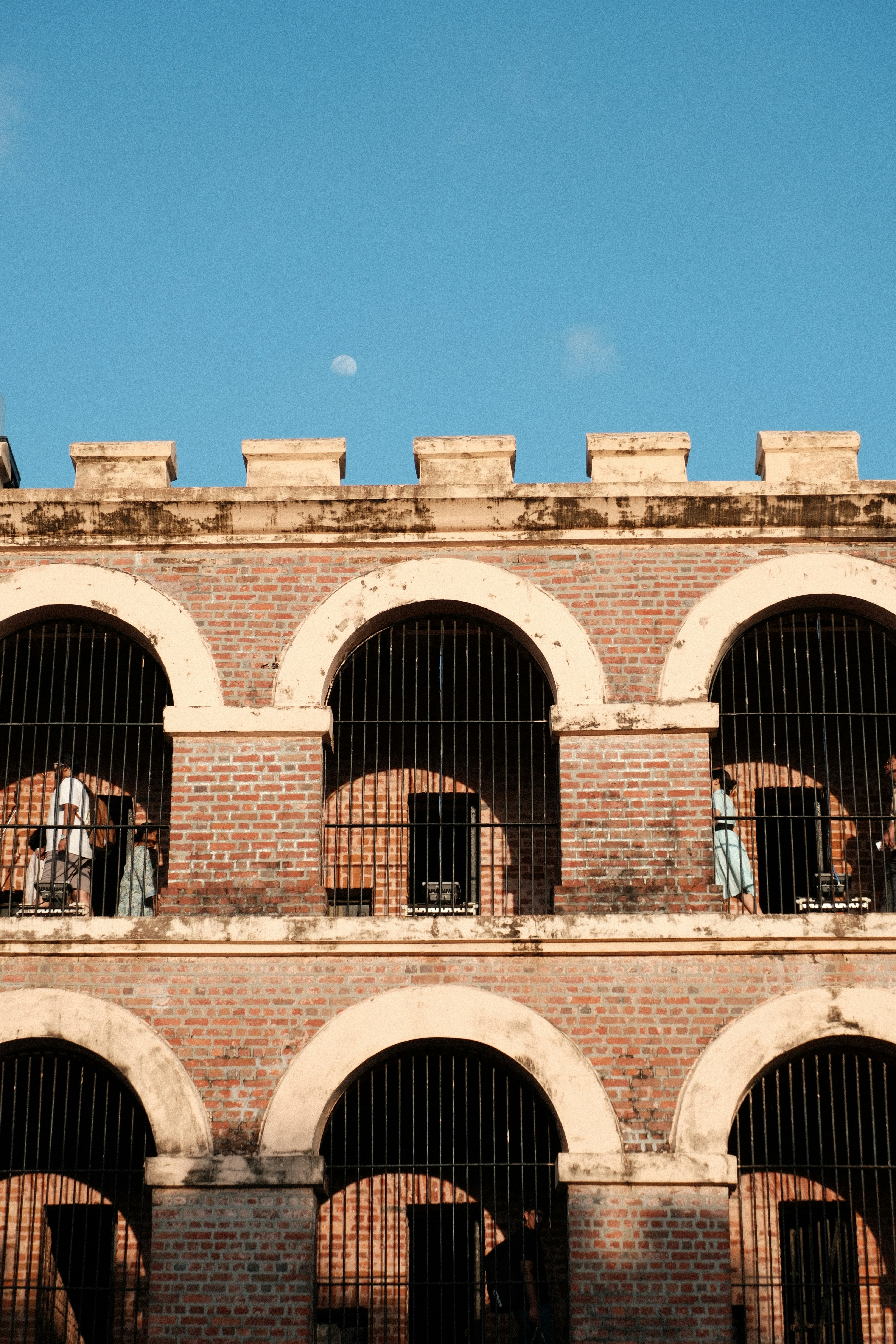 Brick Arches Against a Blue Sky, with Moon Above