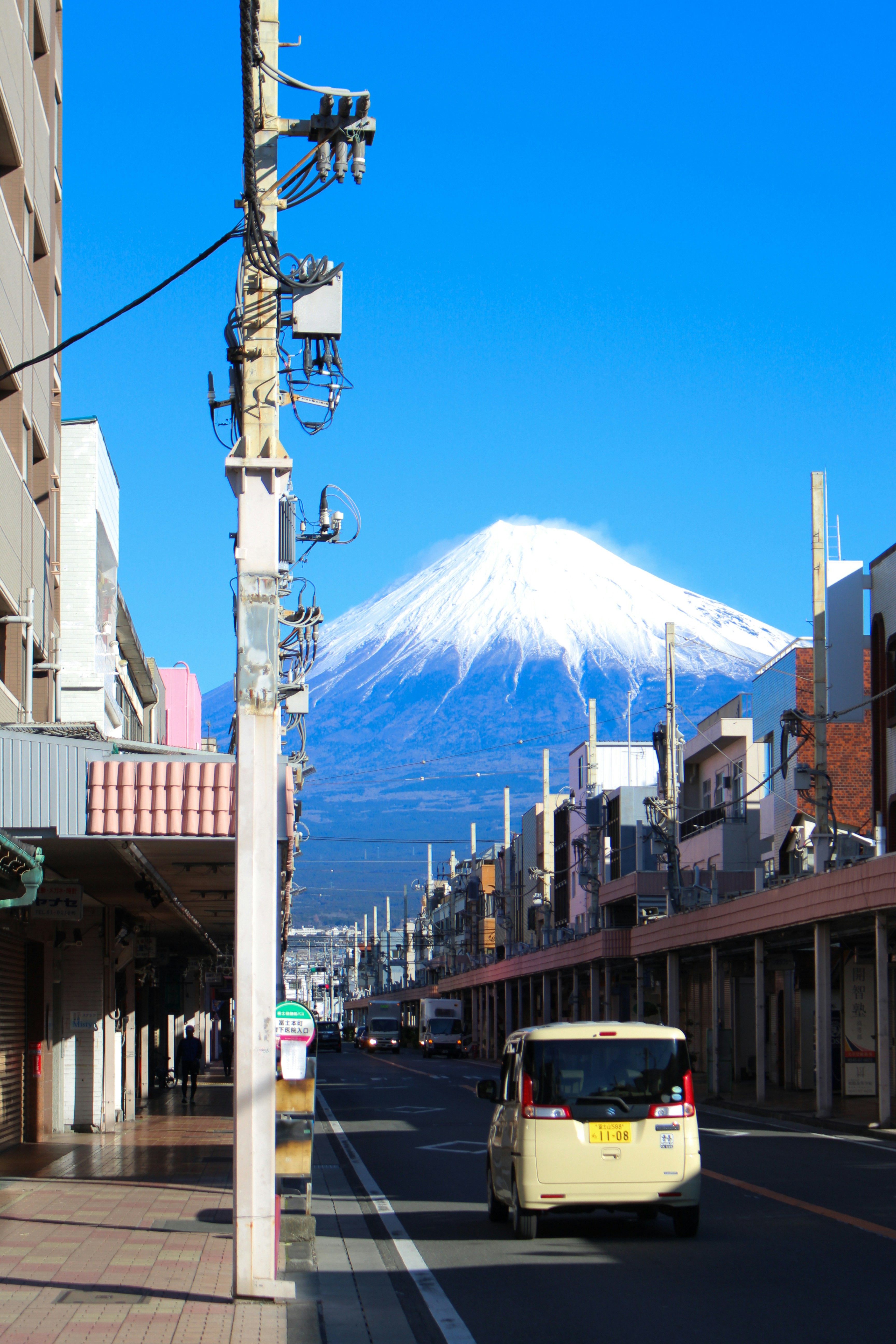 Snow-Capped Fuji framed by a sunlit urban street