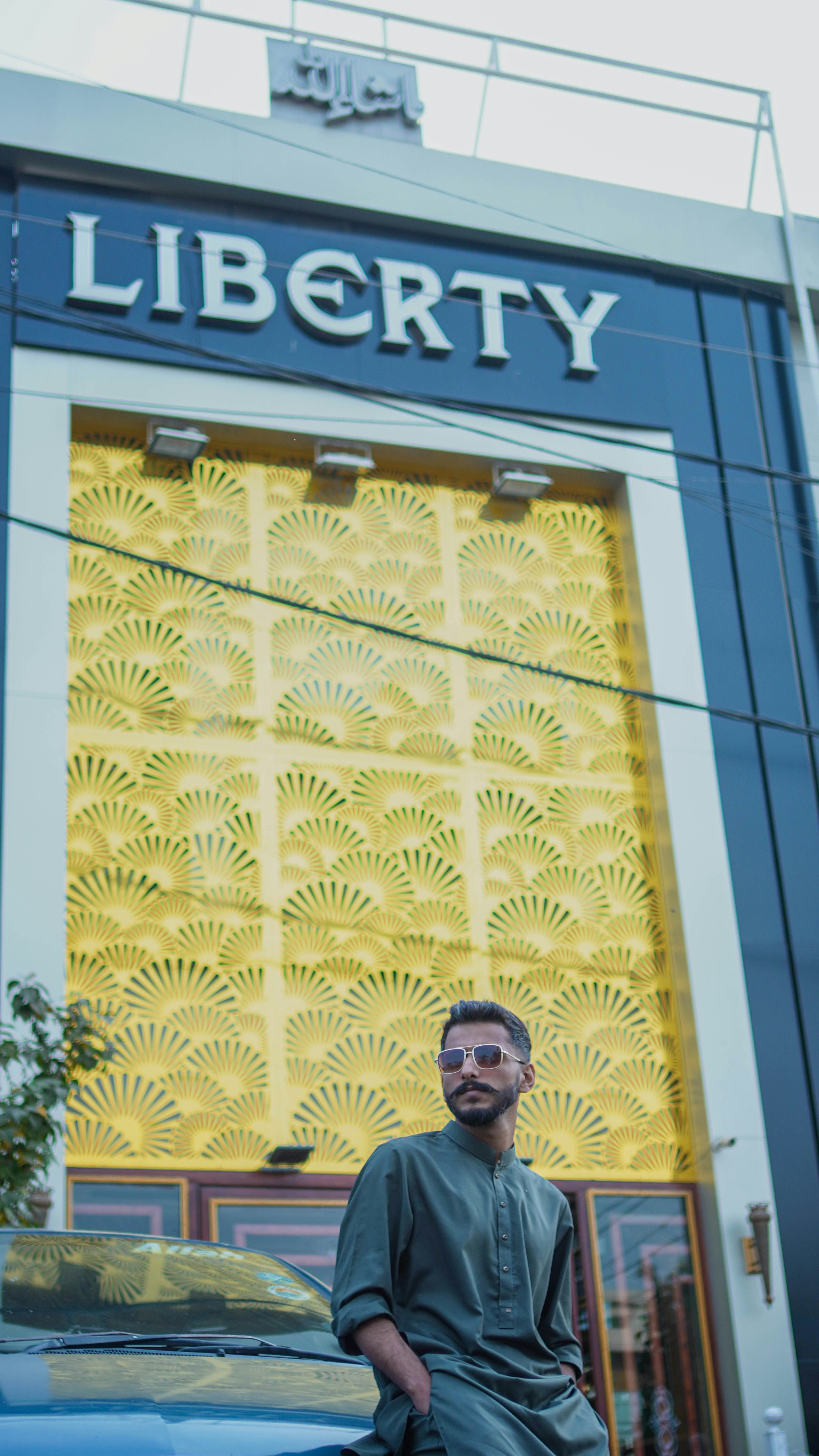 Portrait at the Liberty Gate: Modern Attire Against Ornate Yellow Backdrop