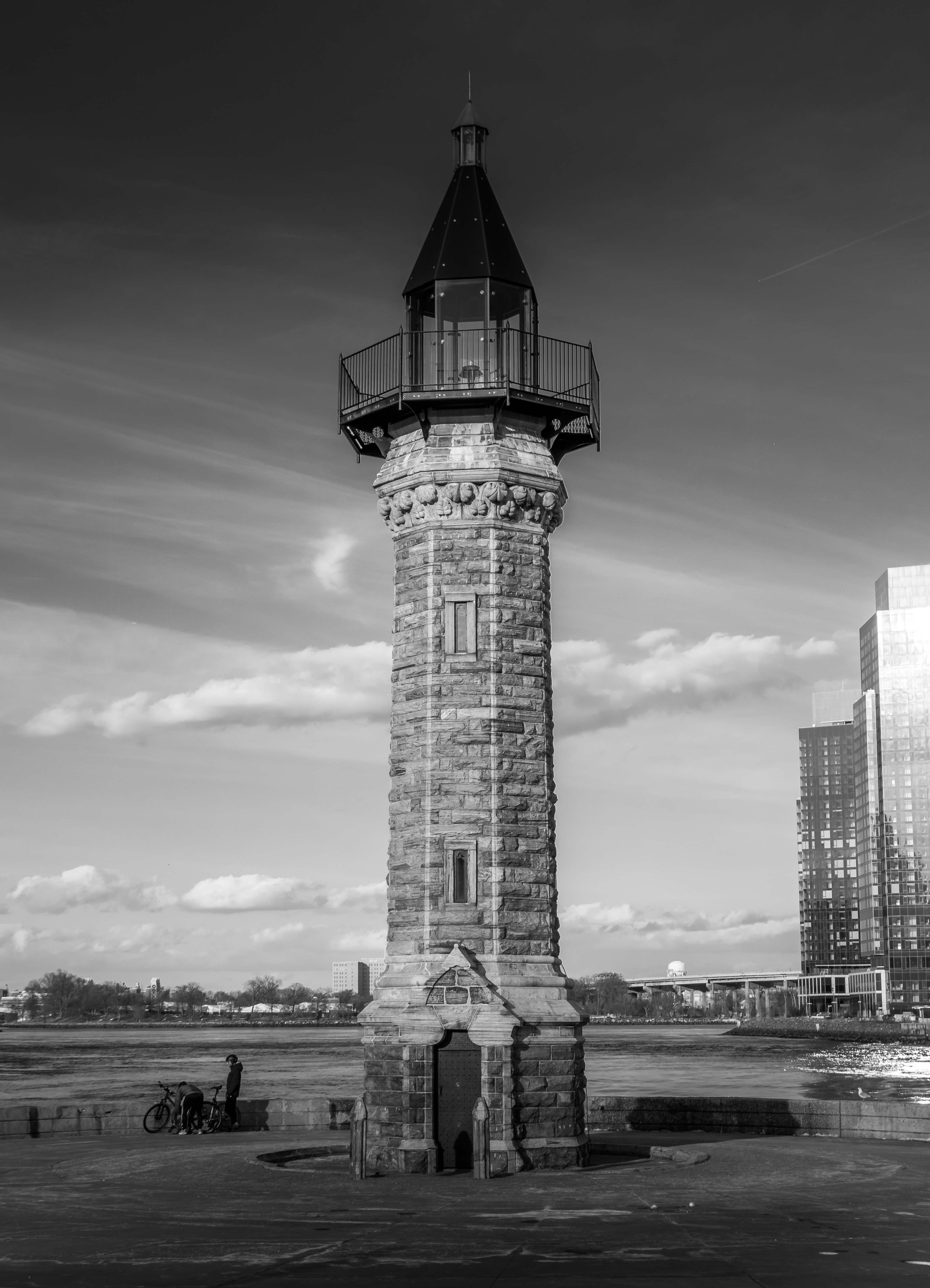 Lighthouse in Black and White: Stone Sentinel Overlooking the Riverfront
