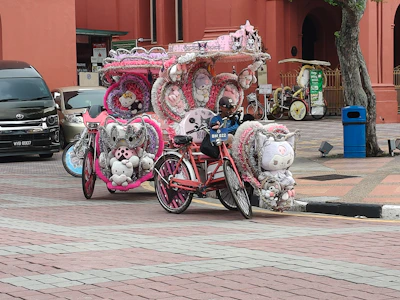 Colorful pedicab parade: plush-carriage wheels and cyclists near a red façade