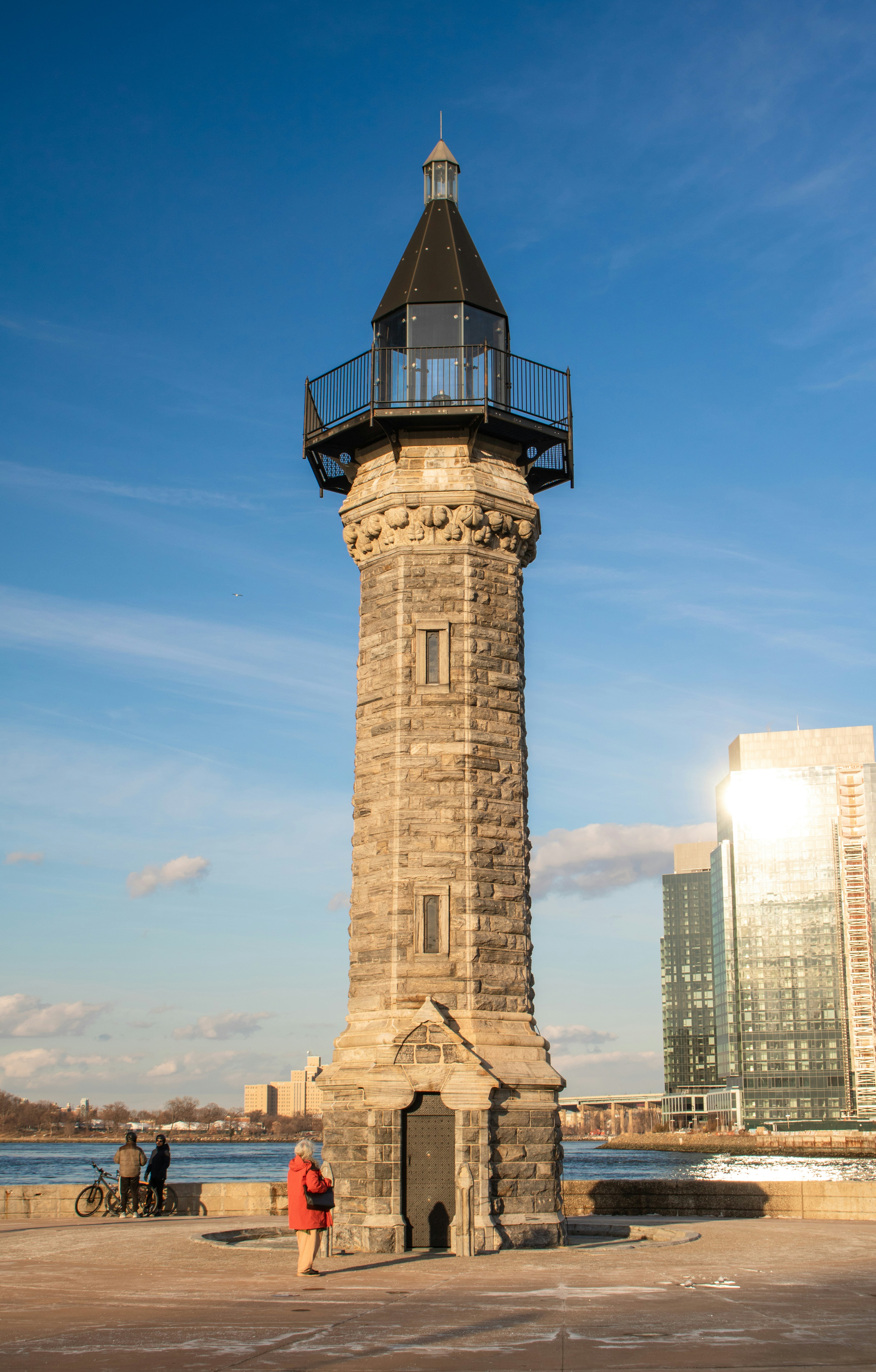 A photograph of the Roosevelt Island Lighthouse, also known as the Blackwell Island Light, showing a Gothic Revival stone lighthouse tower built in 1872 at the northern tip of Roosevelt Island in New York City. The image documents historic masonry construction using local gneiss, architectural detailing, and landmark preservation. It can be used for topics related to maritime history, historic landmarks, architectural heritage, urban waterfronts, restoration projects, and New York City history.