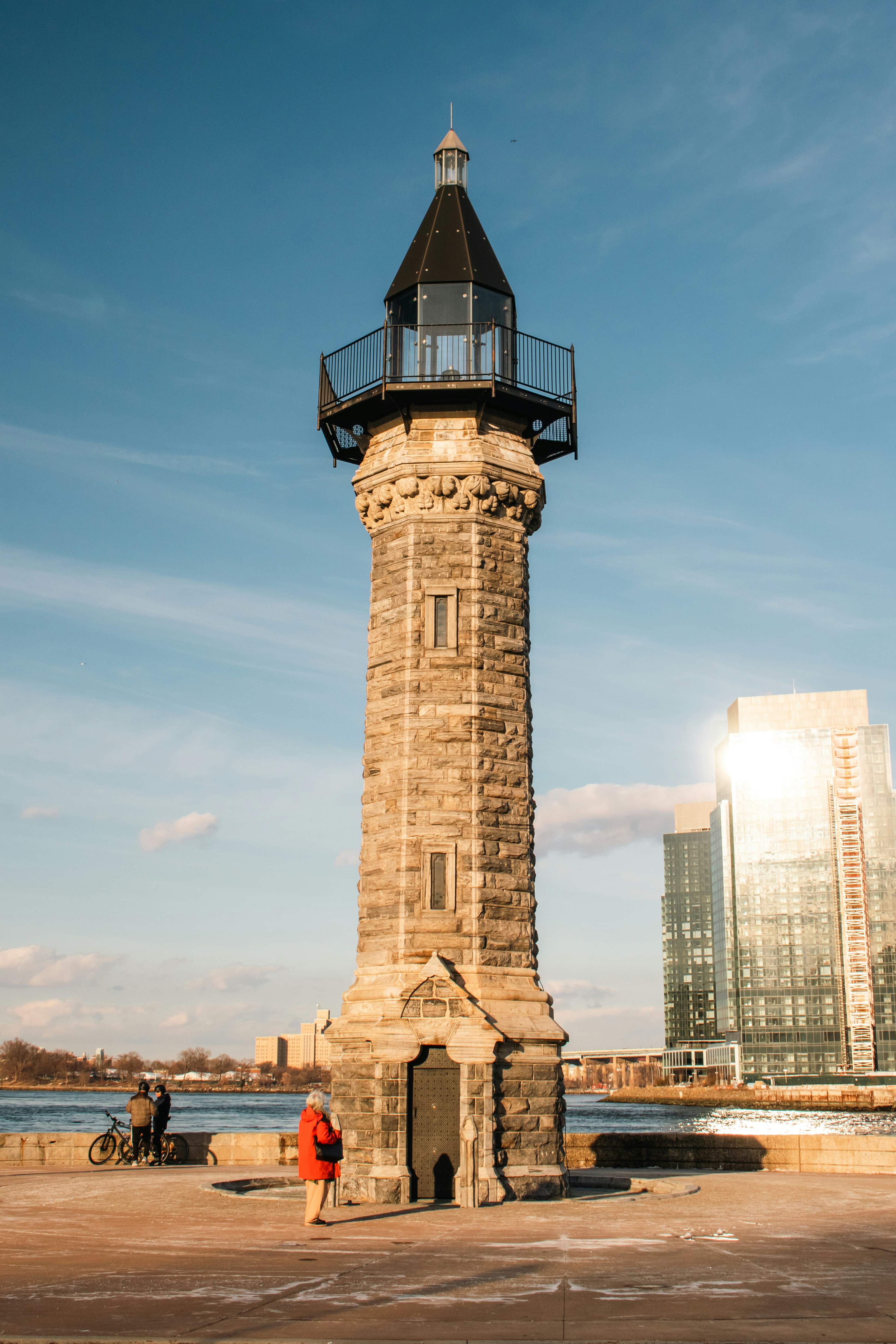 Beacon Above the Waterfront: A Stone Lighthouse Framed at Dusk