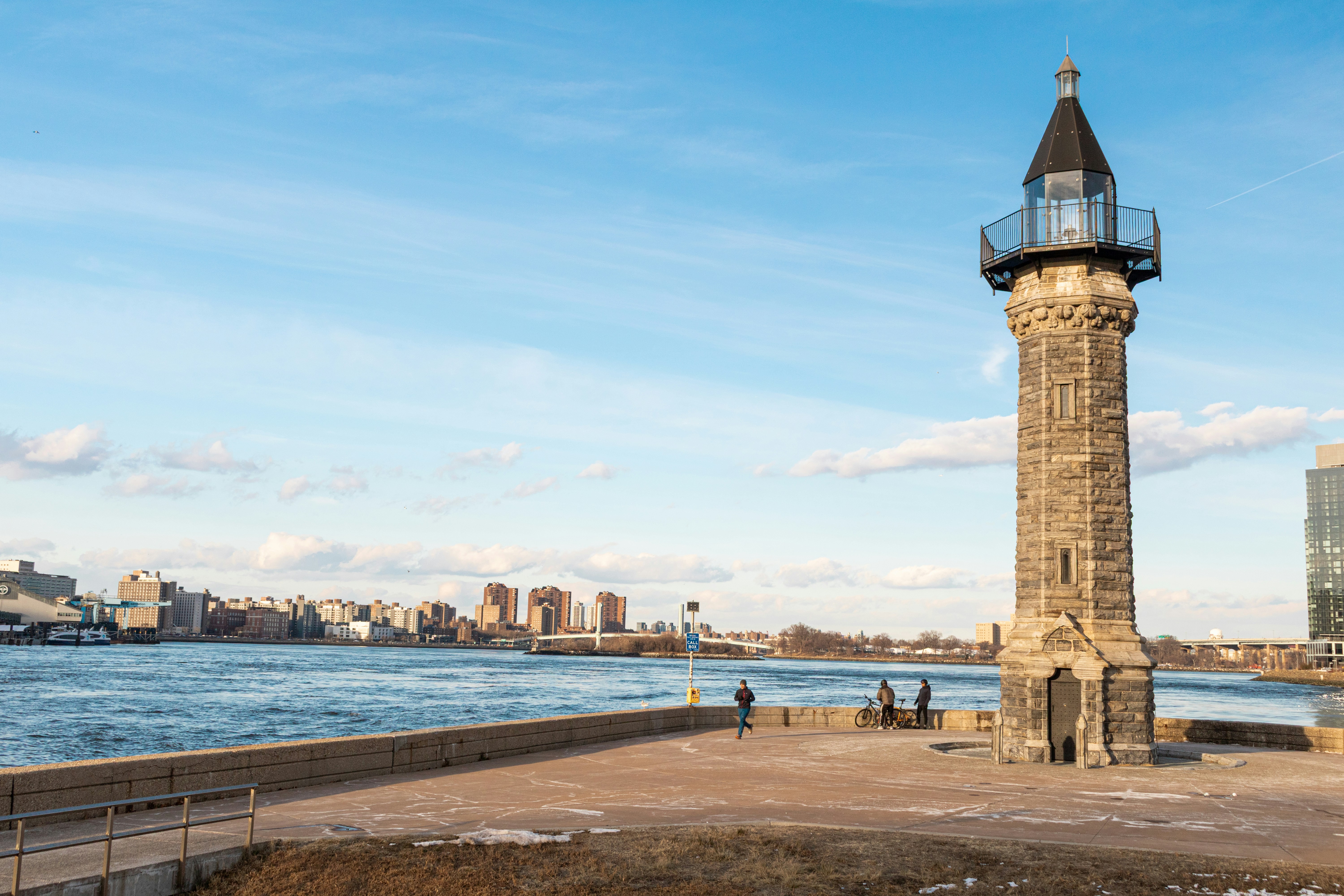 A photograph of the Roosevelt Island Lighthouse, also known as the Blackwell Island Light, showing a Gothic Revival stone lighthouse tower built in 1872 at the northern tip of Roosevelt Island in New York City. The image documents historic masonry construction using local gneiss, architectural detailing, and landmark preservation. It can be used for topics related to maritime history, historic landmarks, architectural heritage, urban waterfronts, restoration projects, and New York City history.