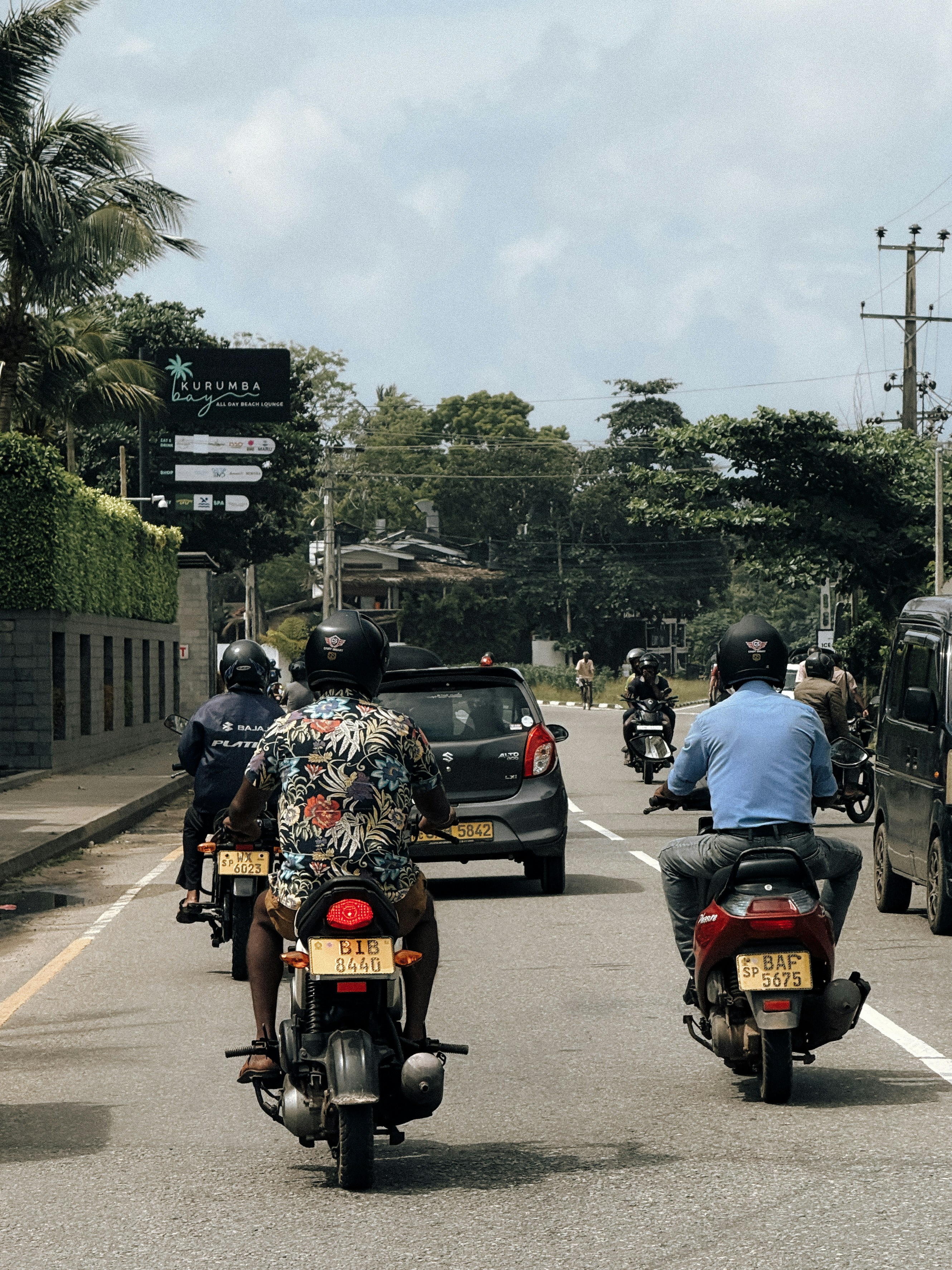 Midday Momentum: Motorcycles and Cars Align Down a Quiet Street