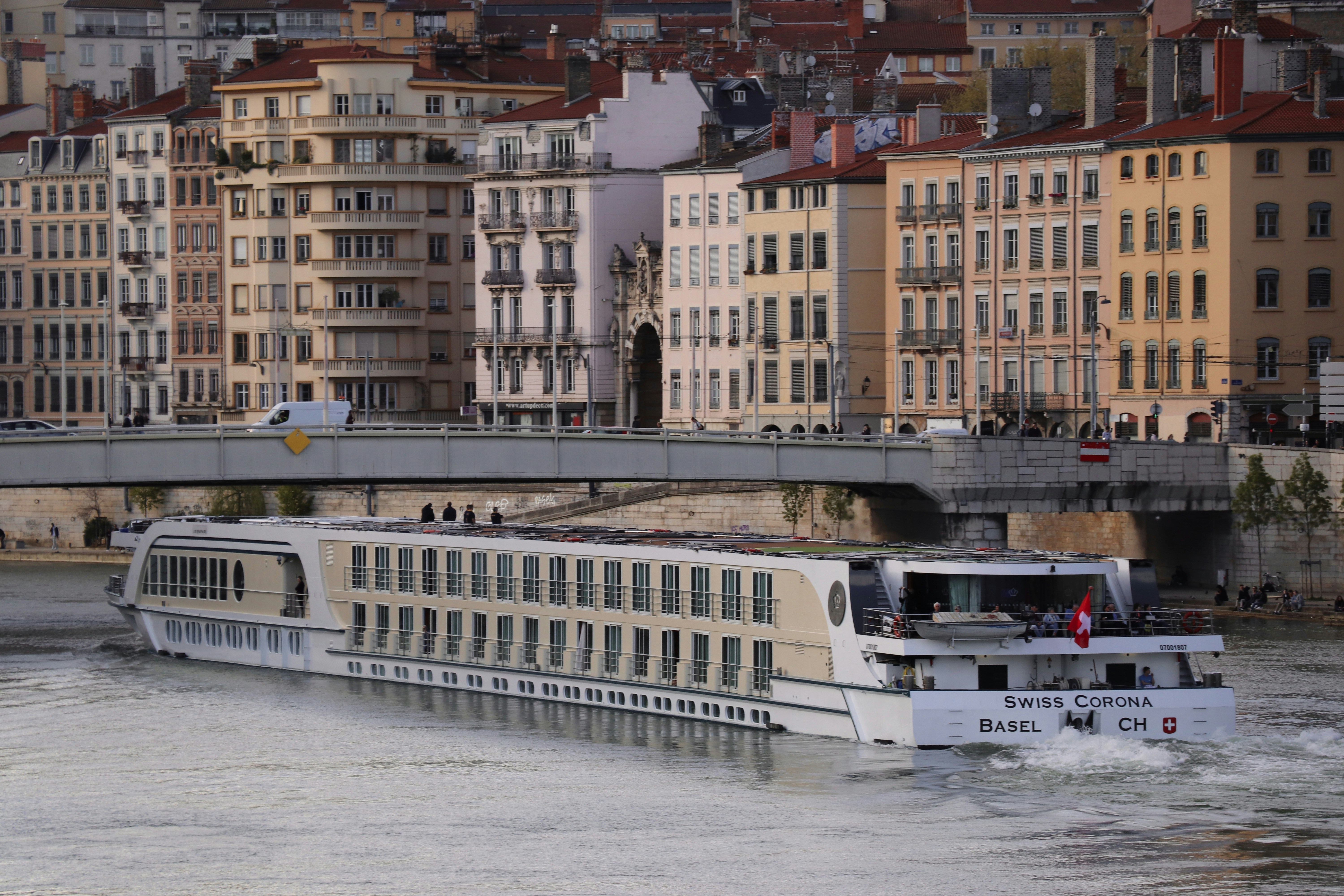 Gliding along the Rhône: a cruise boat slips past a historic riverside panorama