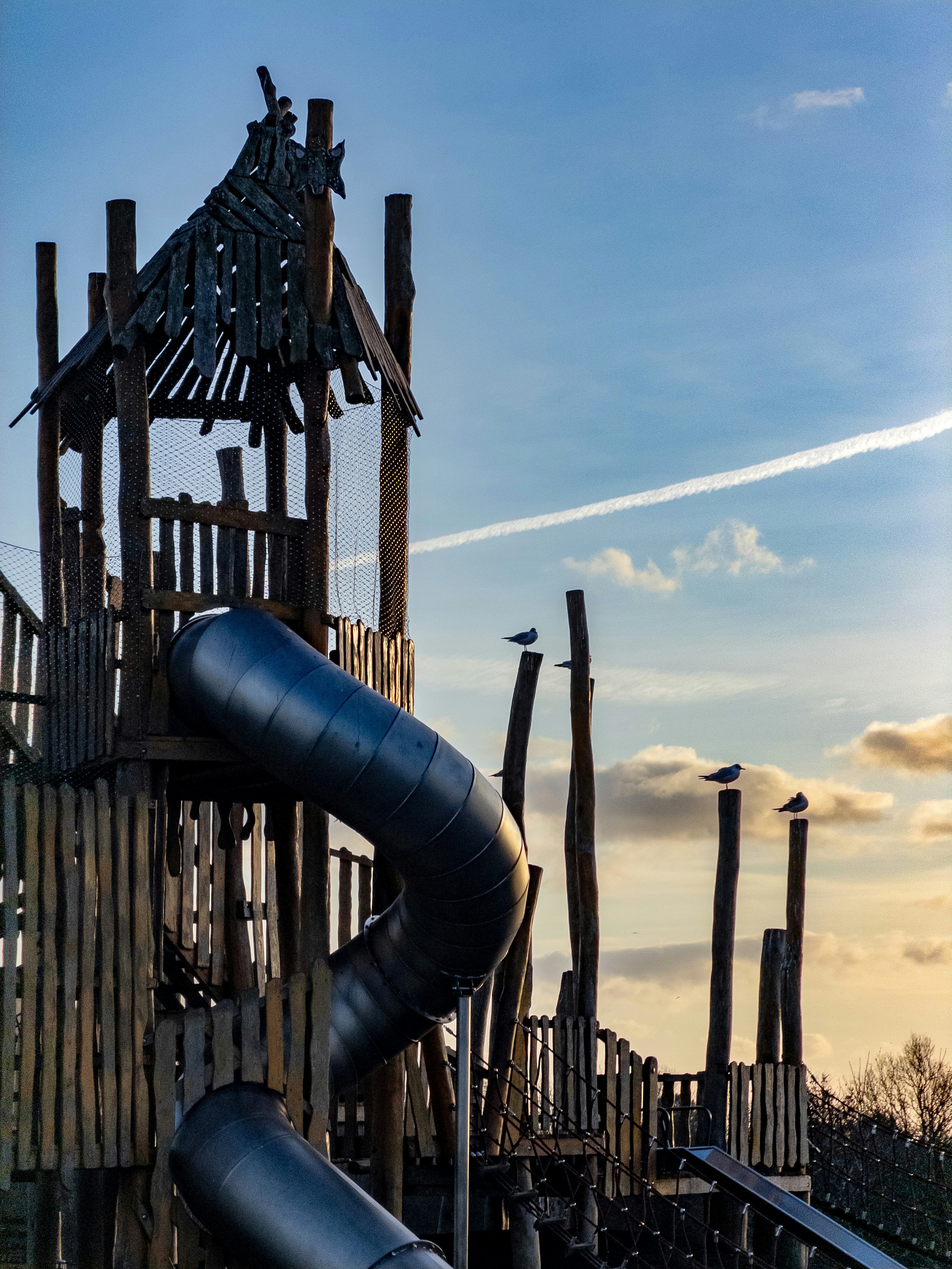 Wooden Play Structure Rises Against a Sunset Sky
