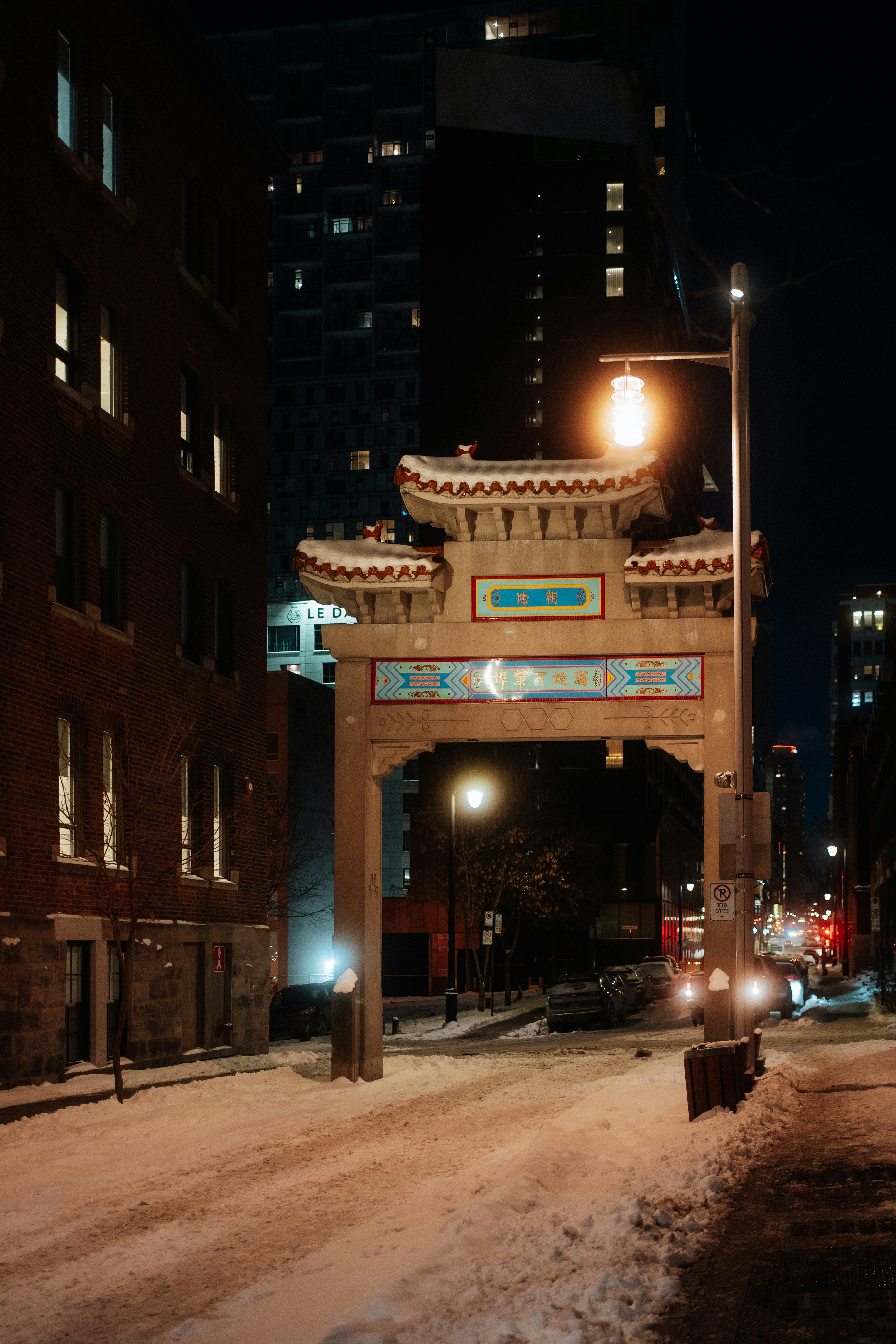 Night Gate: Snow-lit Archway Gilded in Urban Lantern Light