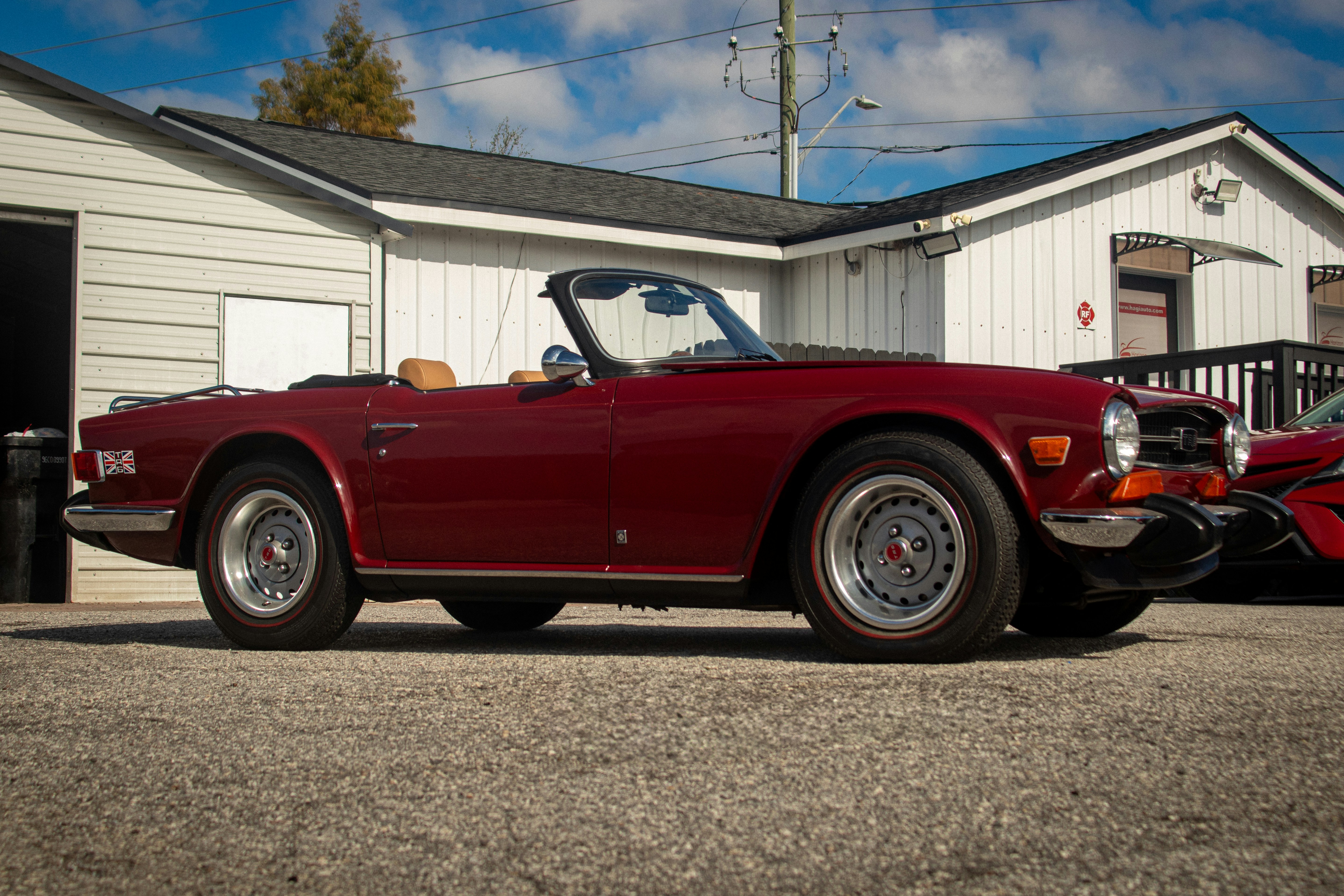 Crimson Convertible in Front of a Quiet Workshop