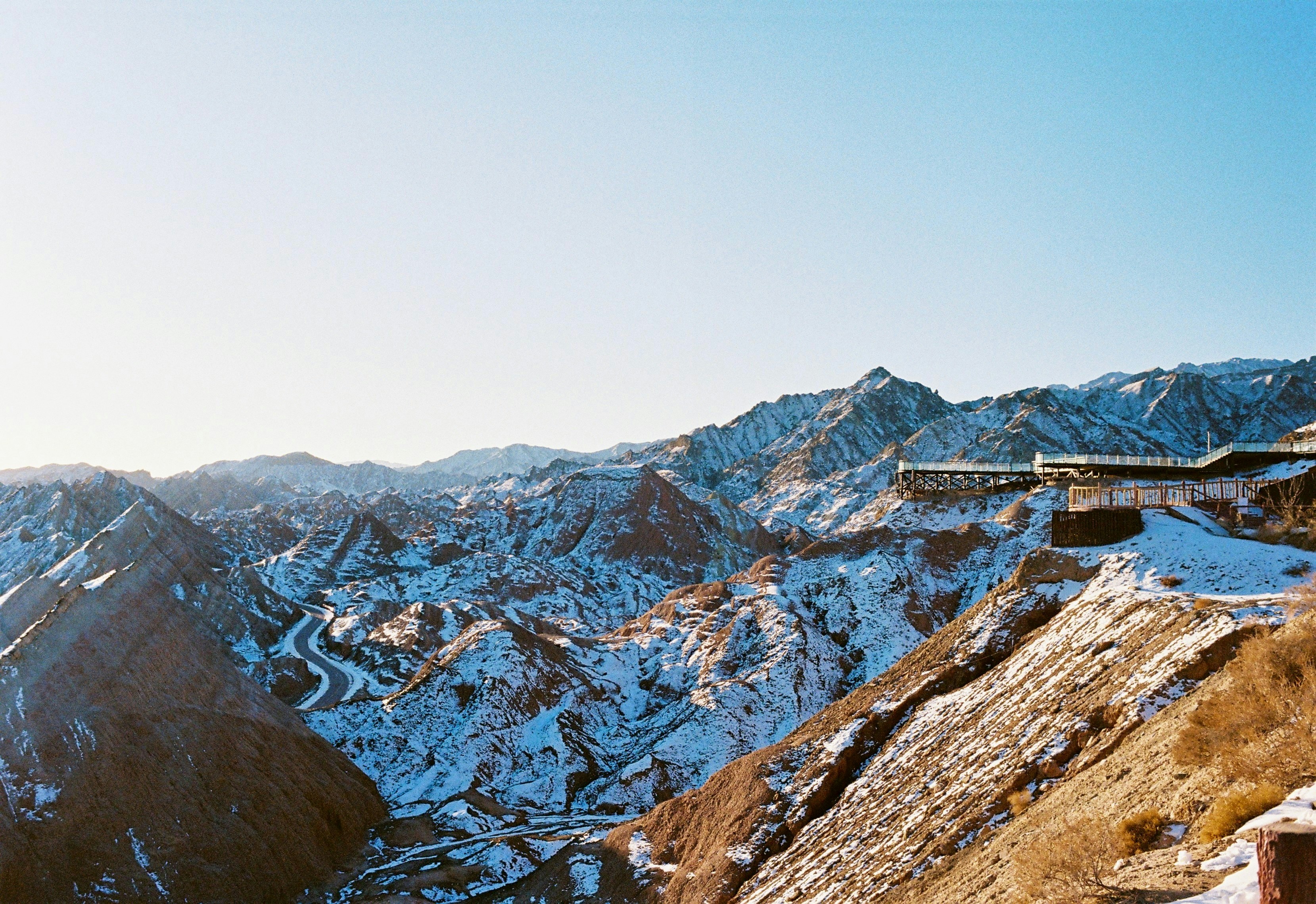 Edge of the Pass: Snow-Capped Peaks and a Cliffside Overlook