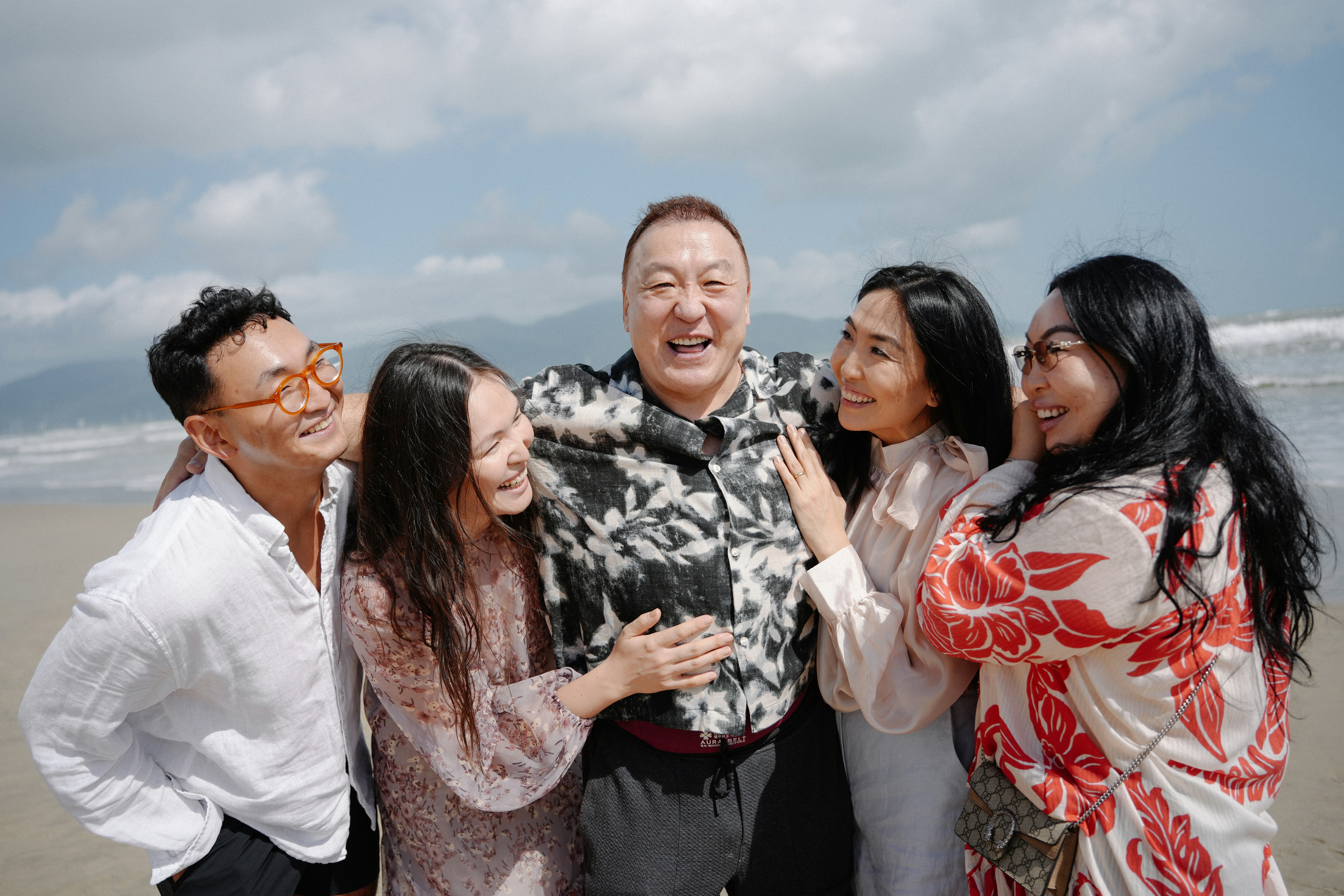 A group of people laughing together on a beach.