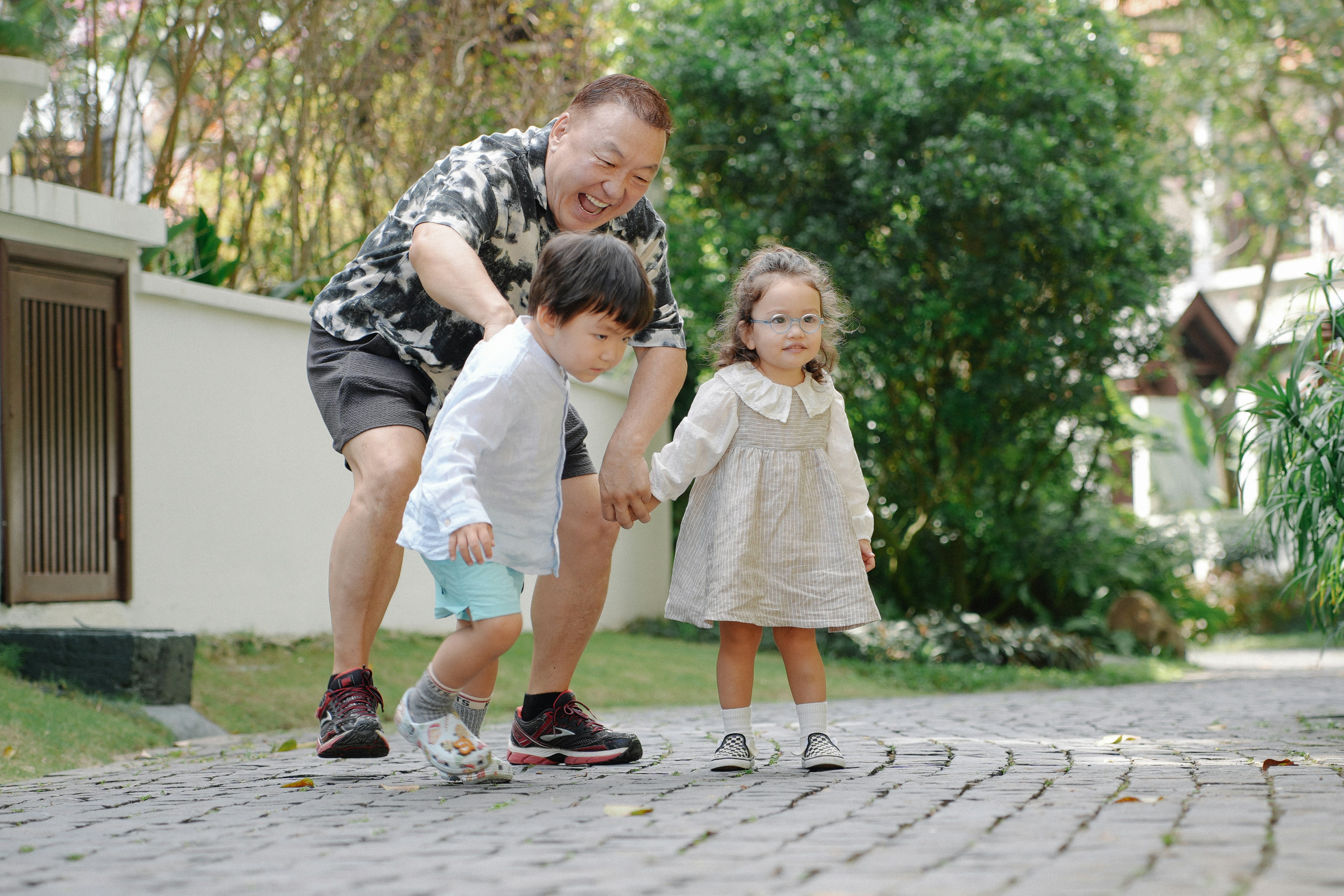 Man playing with two children outdoors
