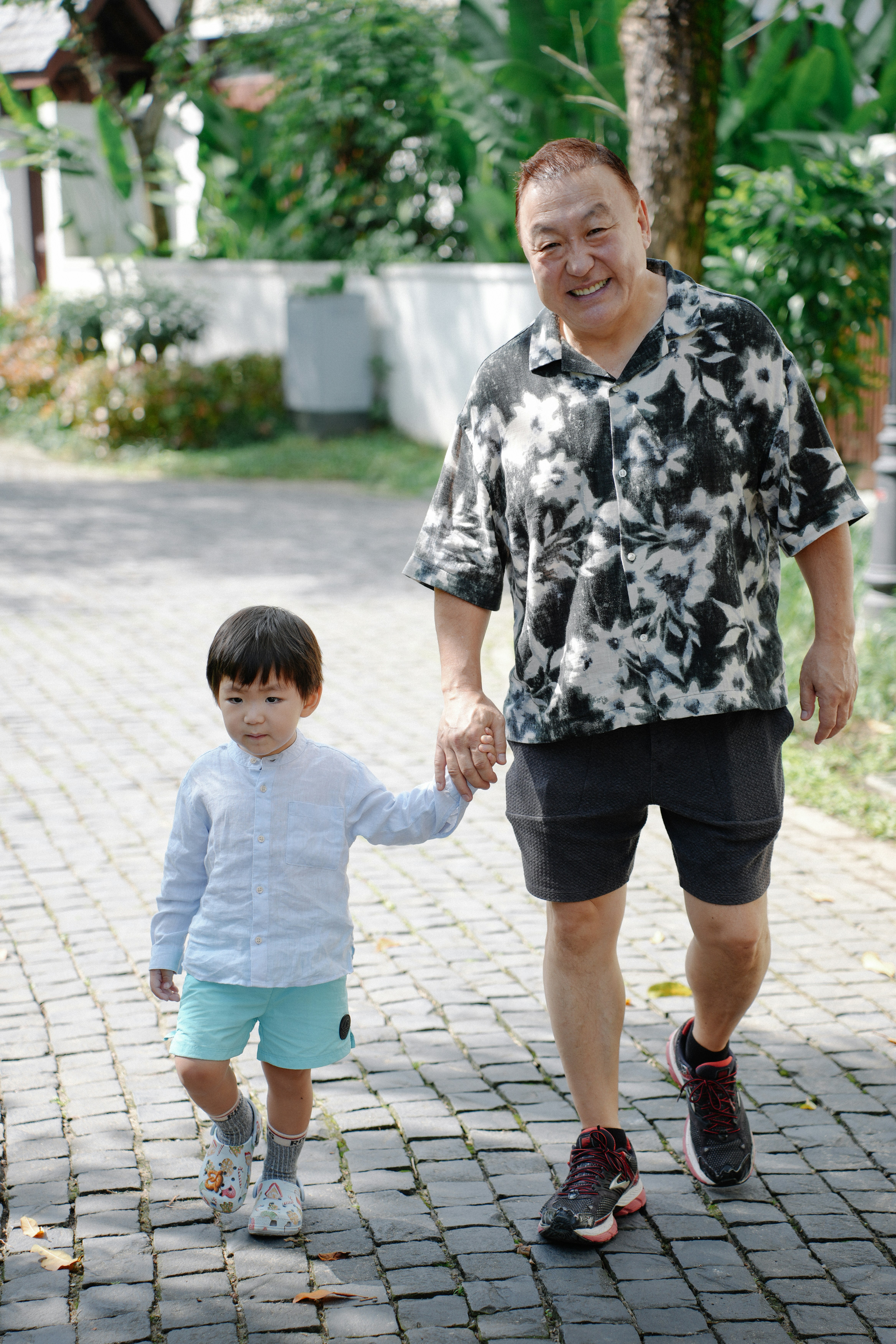 Holding Hands: A Grandfather and Grandchild Step Into Daylight