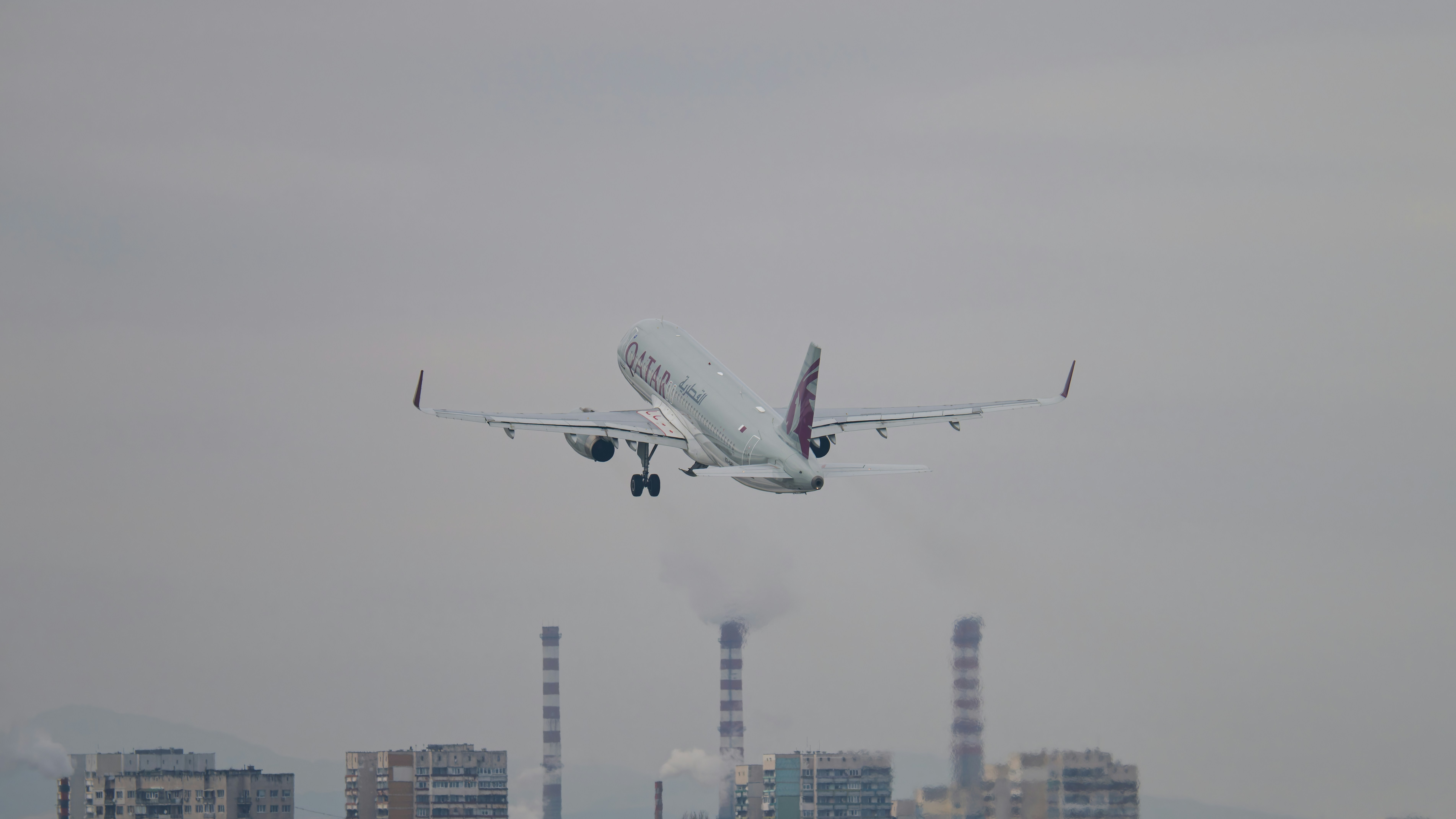 Liftoff Through the Haze: A Jet Climb Above Urban Silhouettes