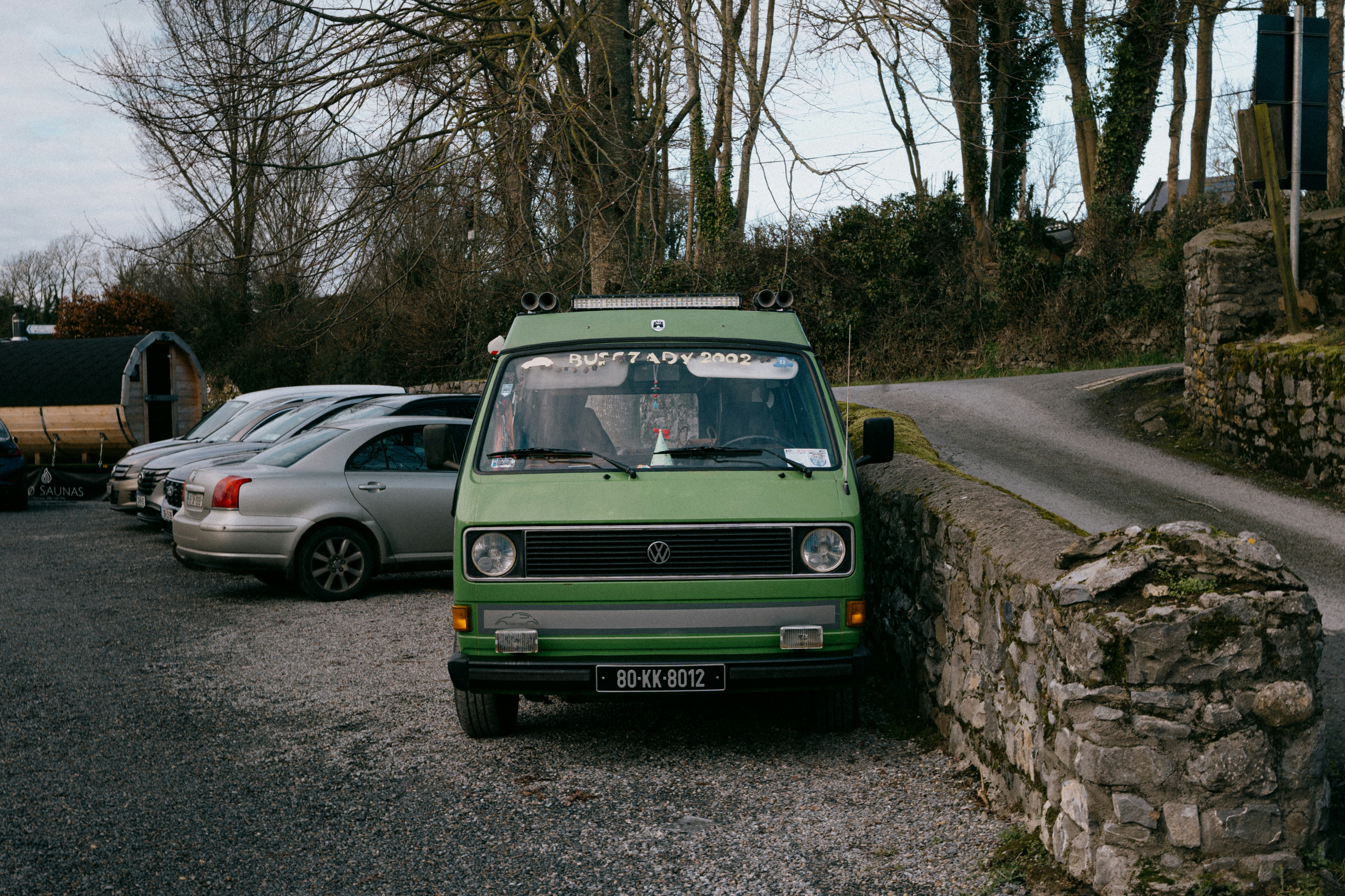 Green Van at the Edge: A Quiet Parking Courtyard