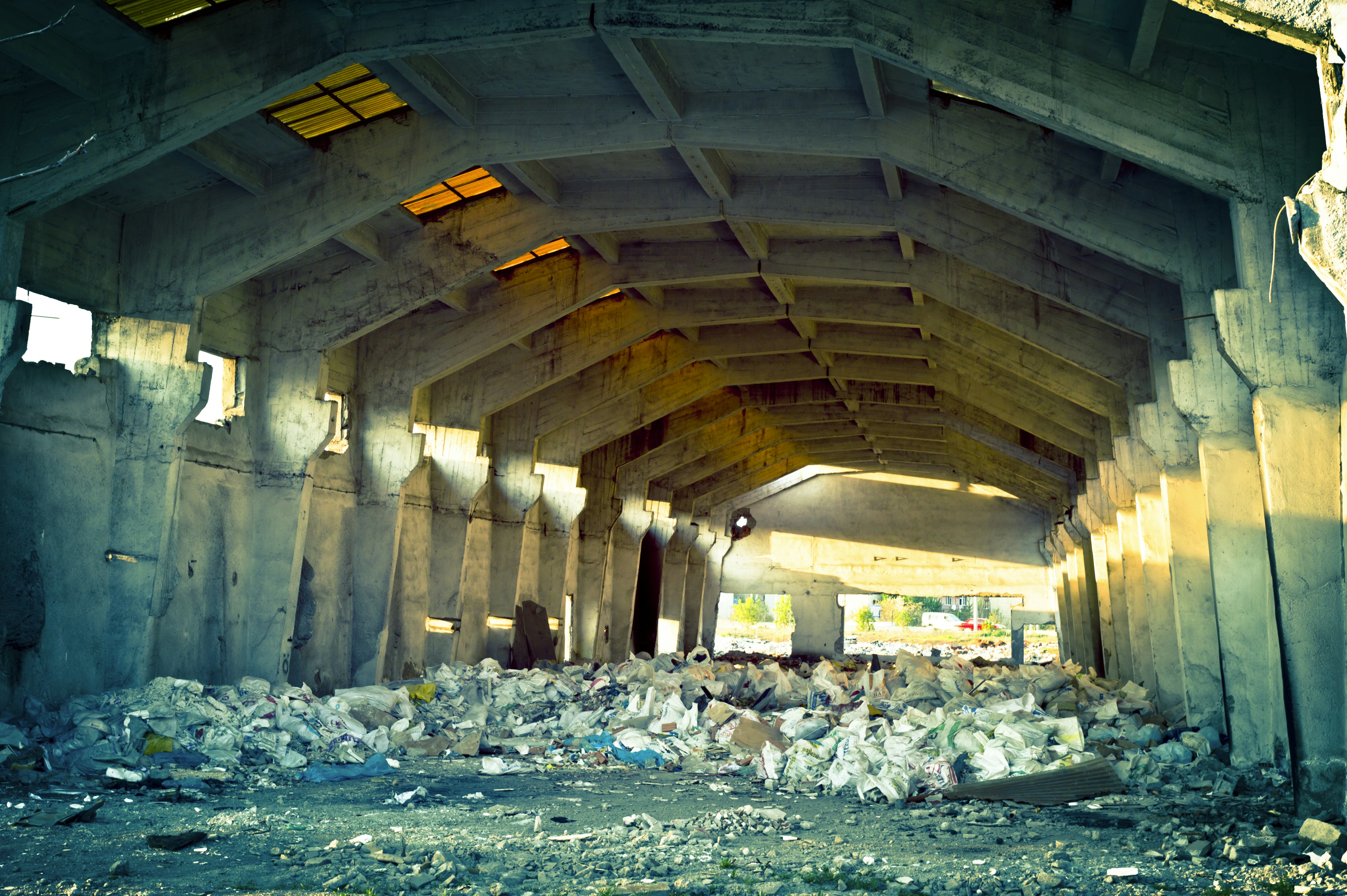Abandoned Arched Hallway: Light Filters Through Crumbling Roof