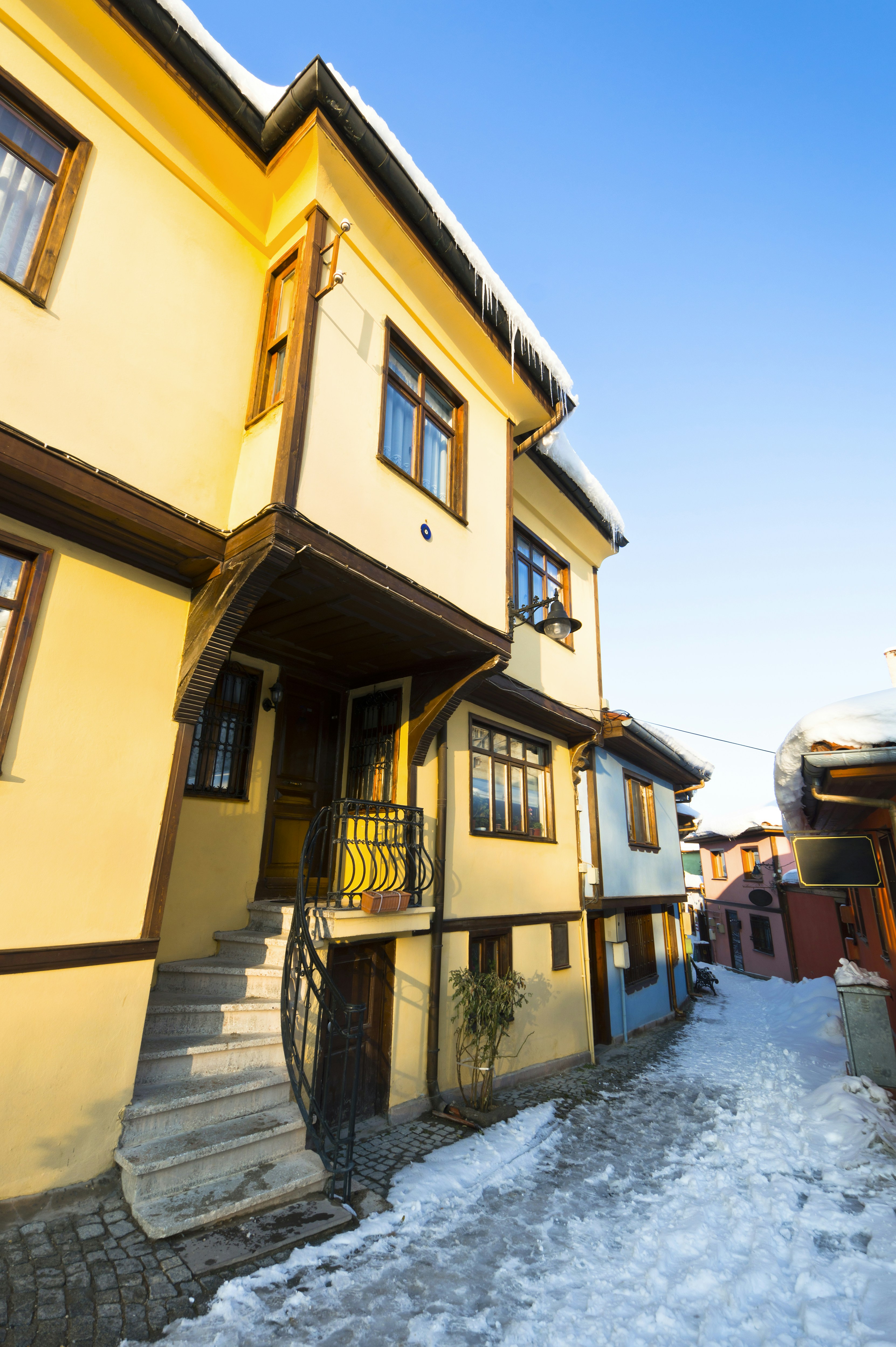 Sunlit Yellow Facades Along Snow-Covered Rua
