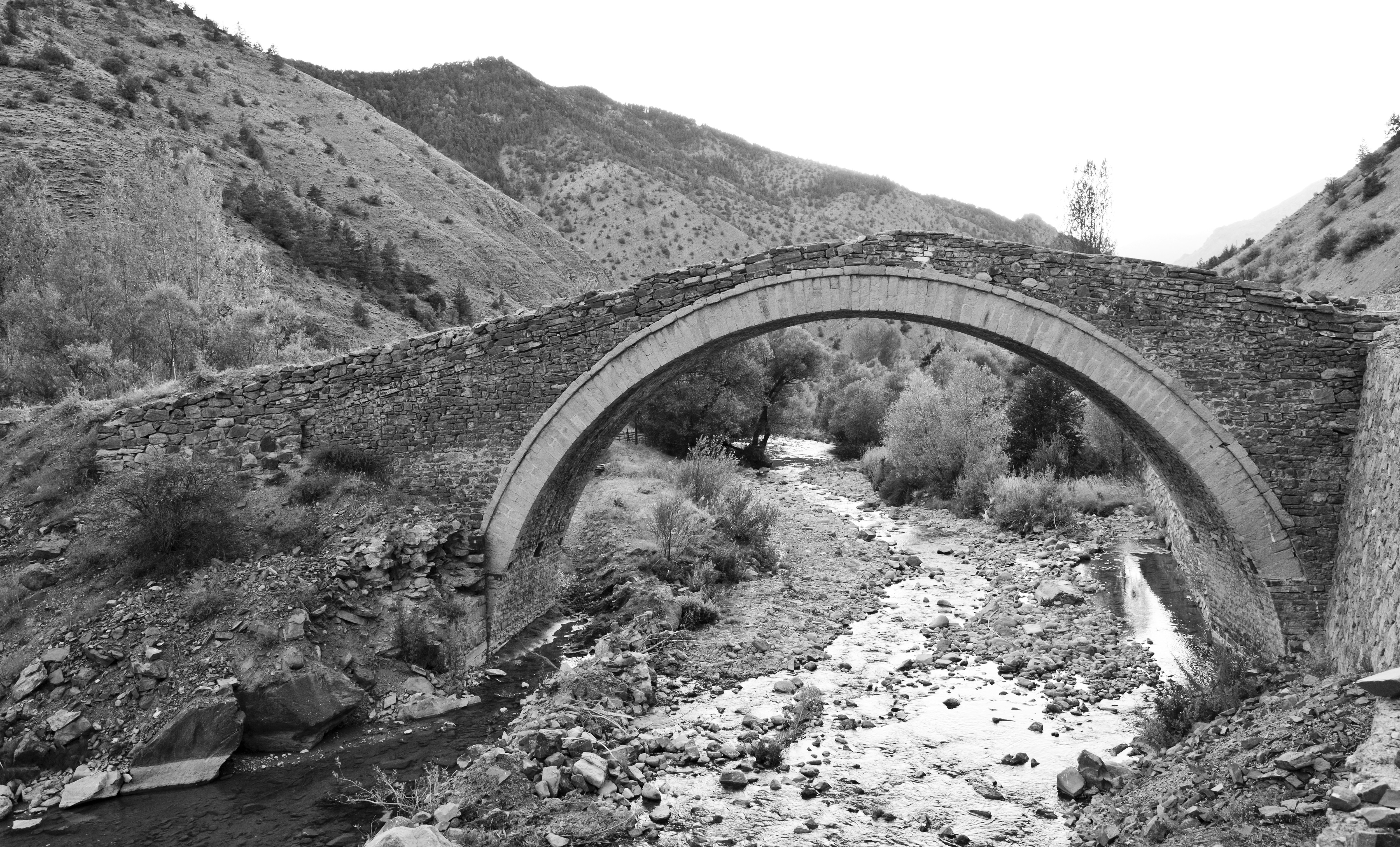 Ancient Arch Over Pebbled Carved Riverbed