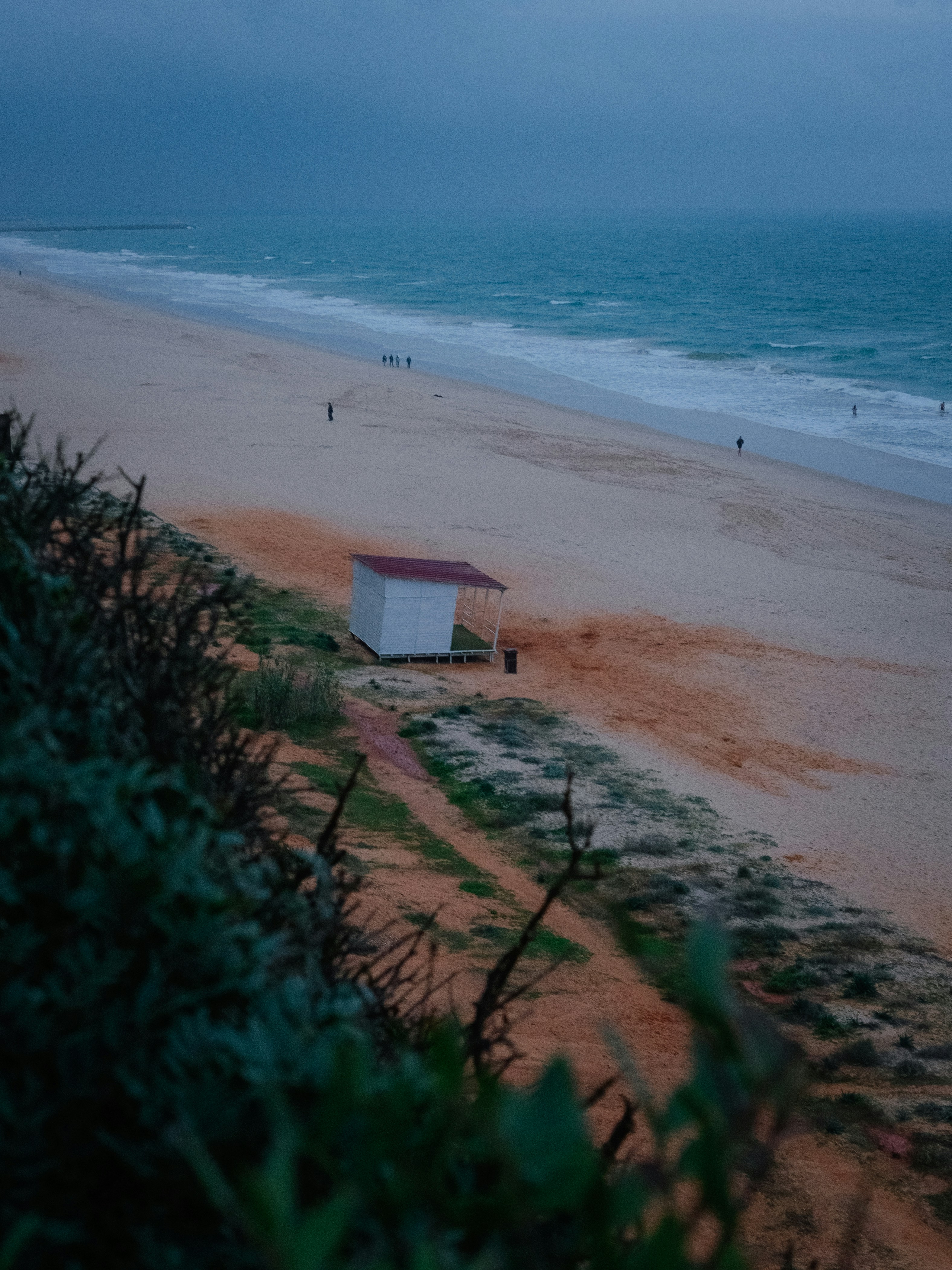 A small white building on a sandy beach. photo – Free Beach Image on ...