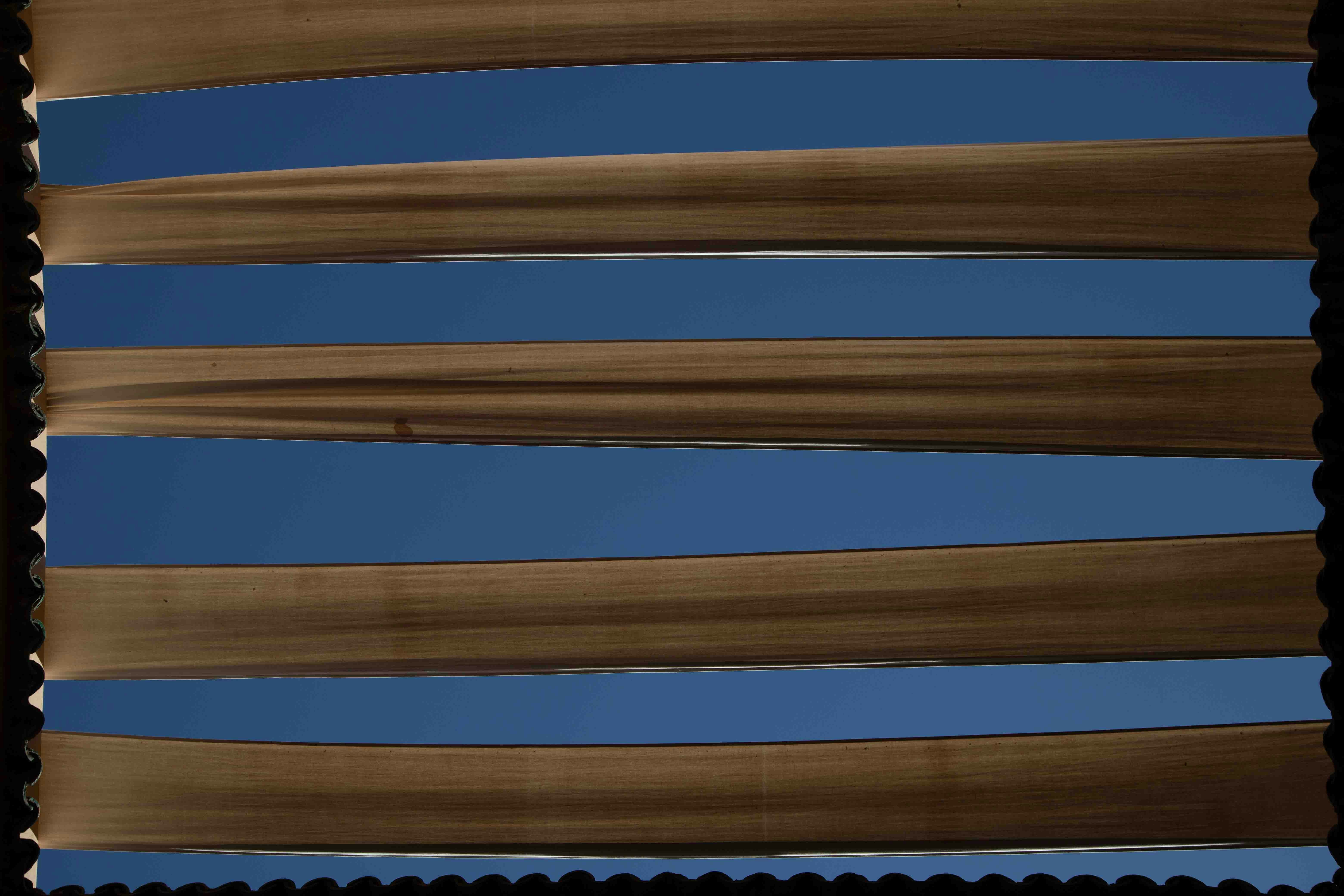Parallel Strata: Wooden Slats Against a Quiet Sky