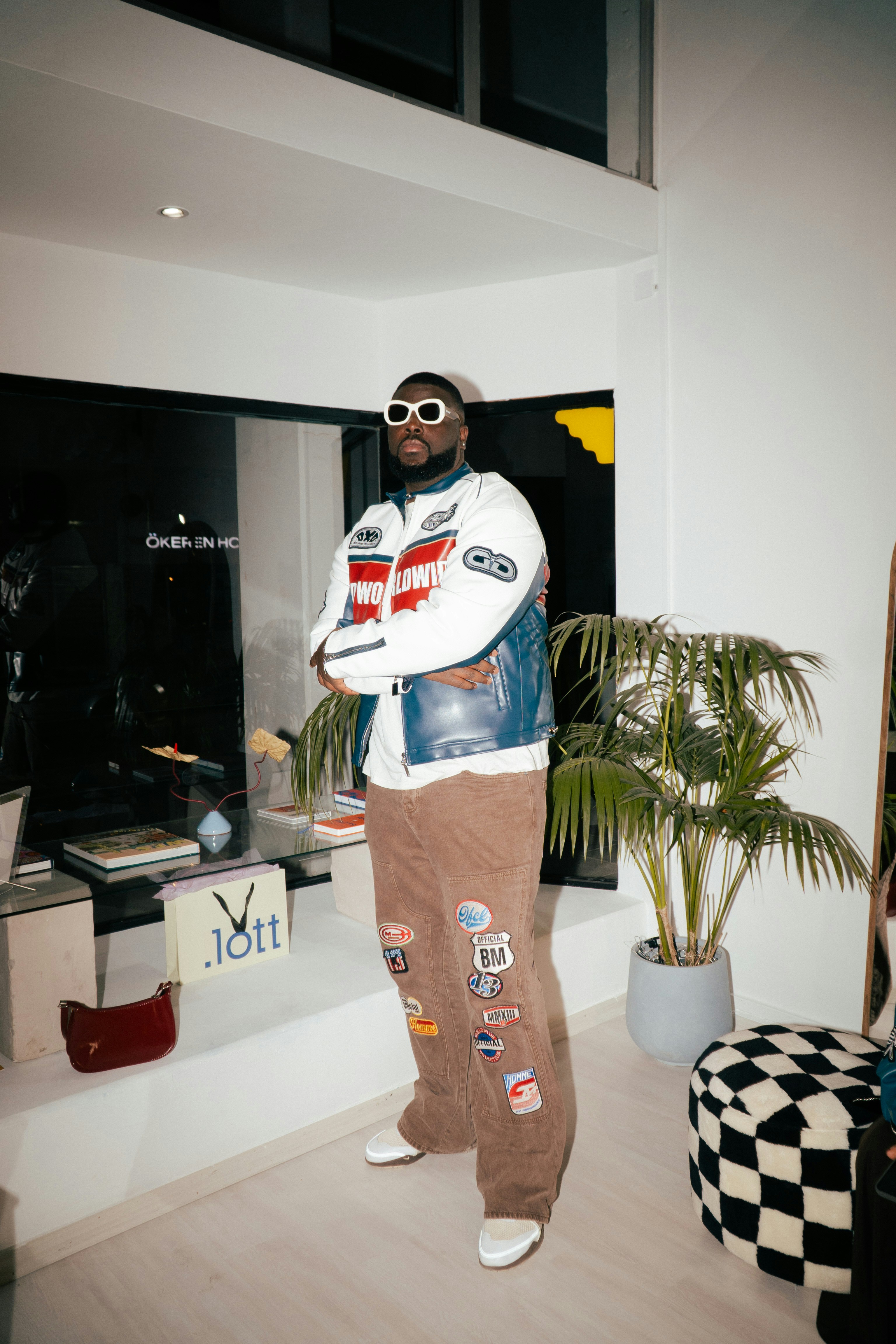 Confident silhouette in a modern lounge wearing patches and retro-inspired shades