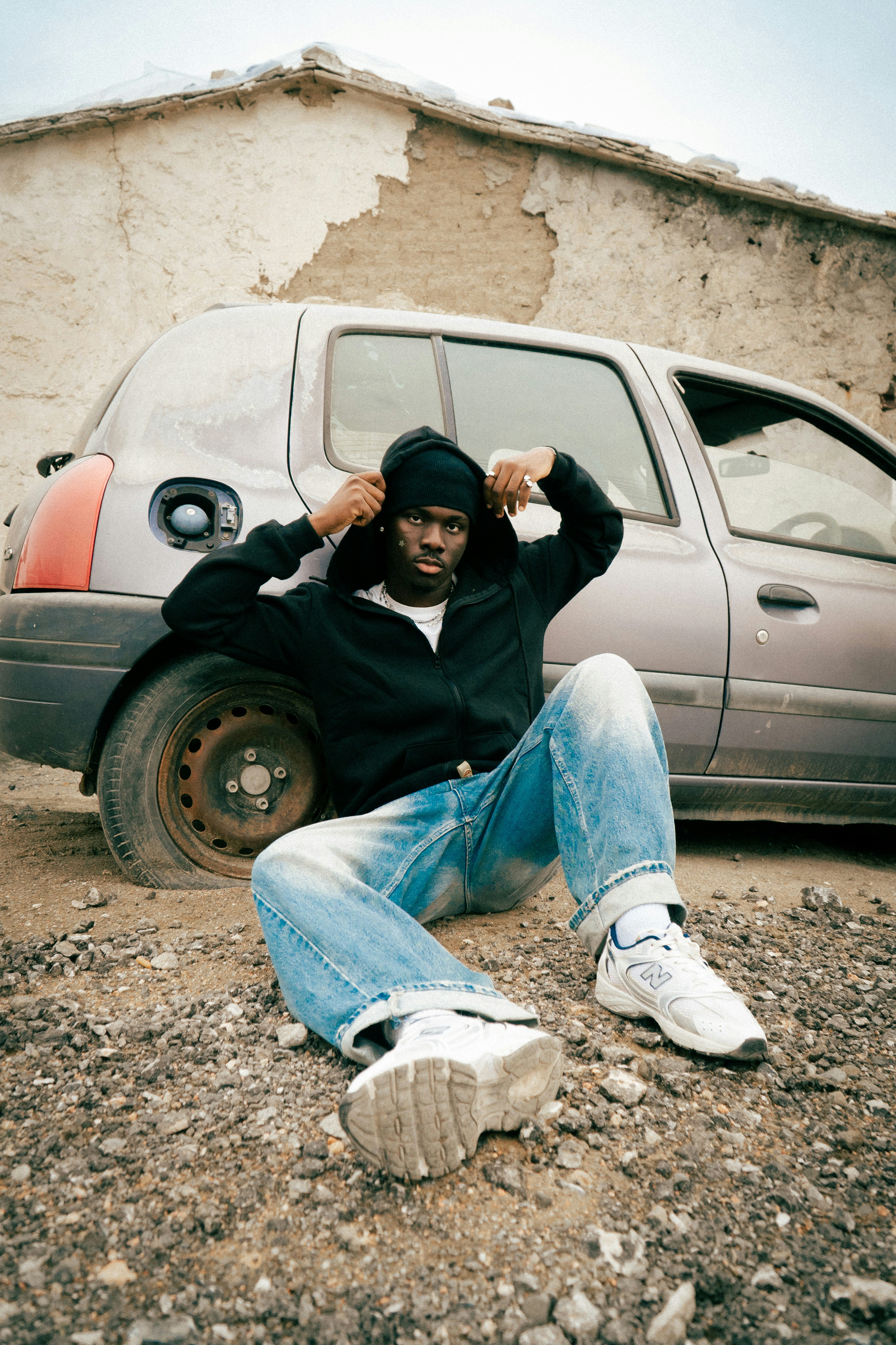 Urban Lullaby: A Harsh Calm Beneath a Broken Car