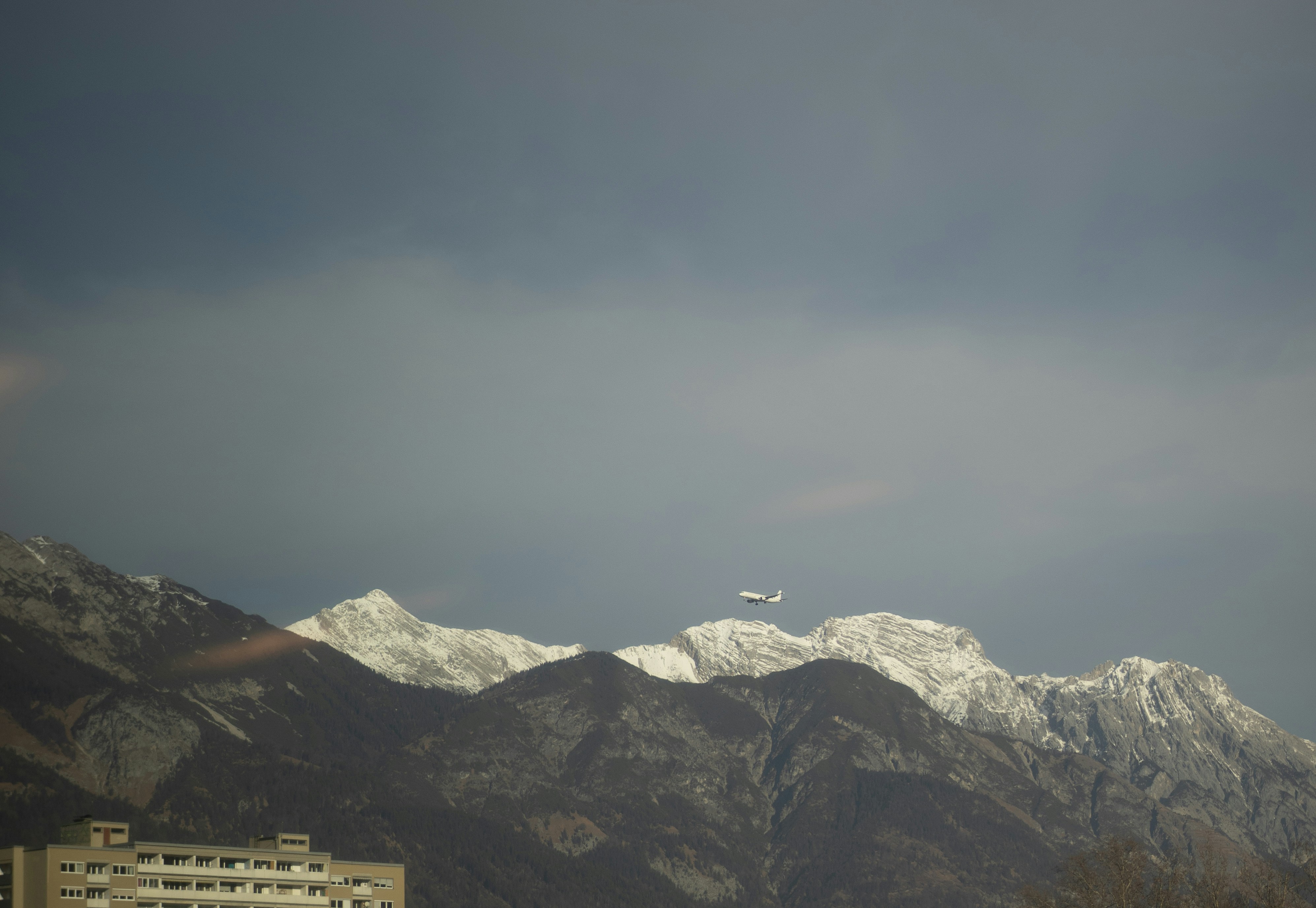 High Altitude Crossing: A lone jet over snow-dusted peaks
