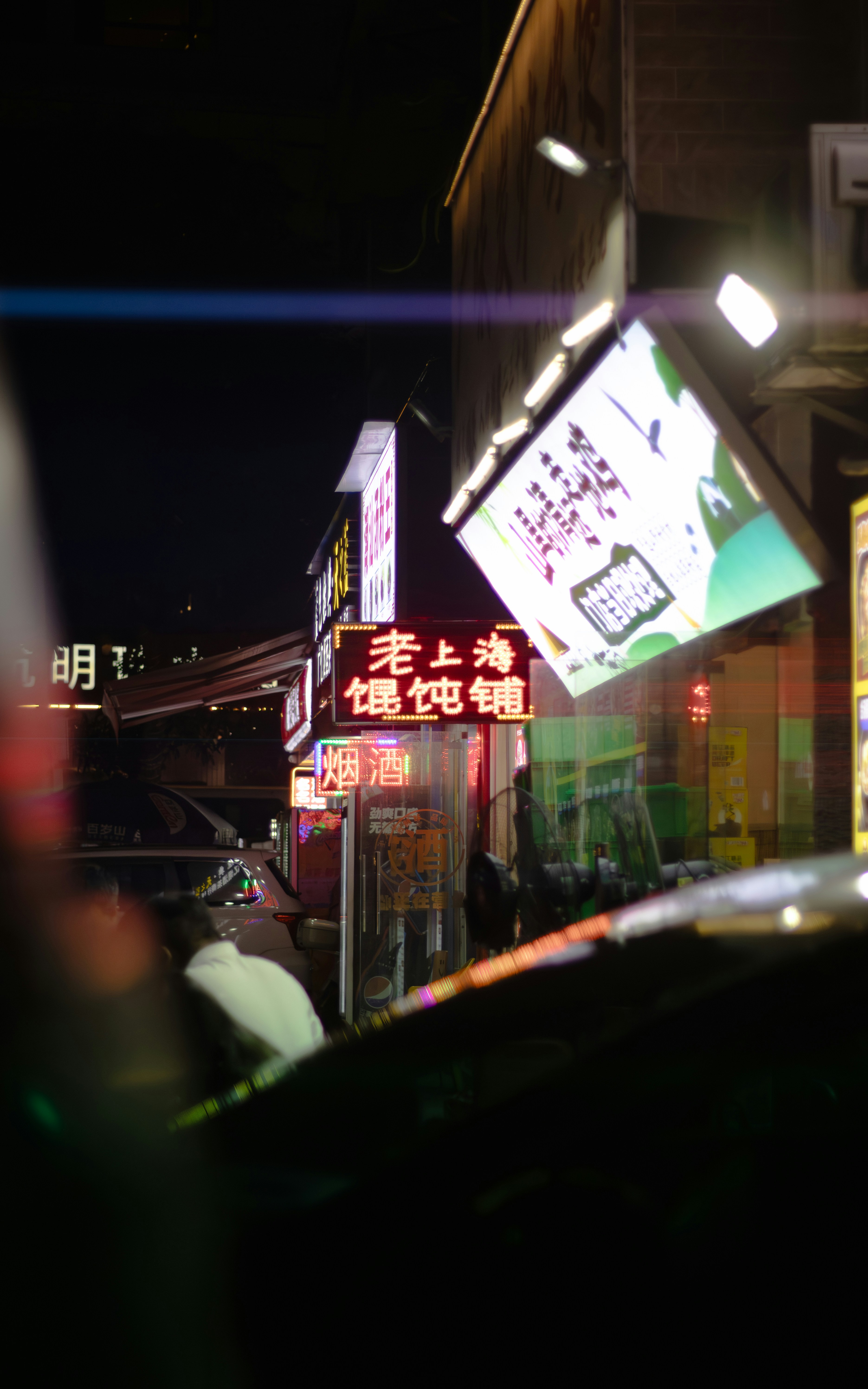 Neon Alley: Nightlife Glow Through the Shopfronts