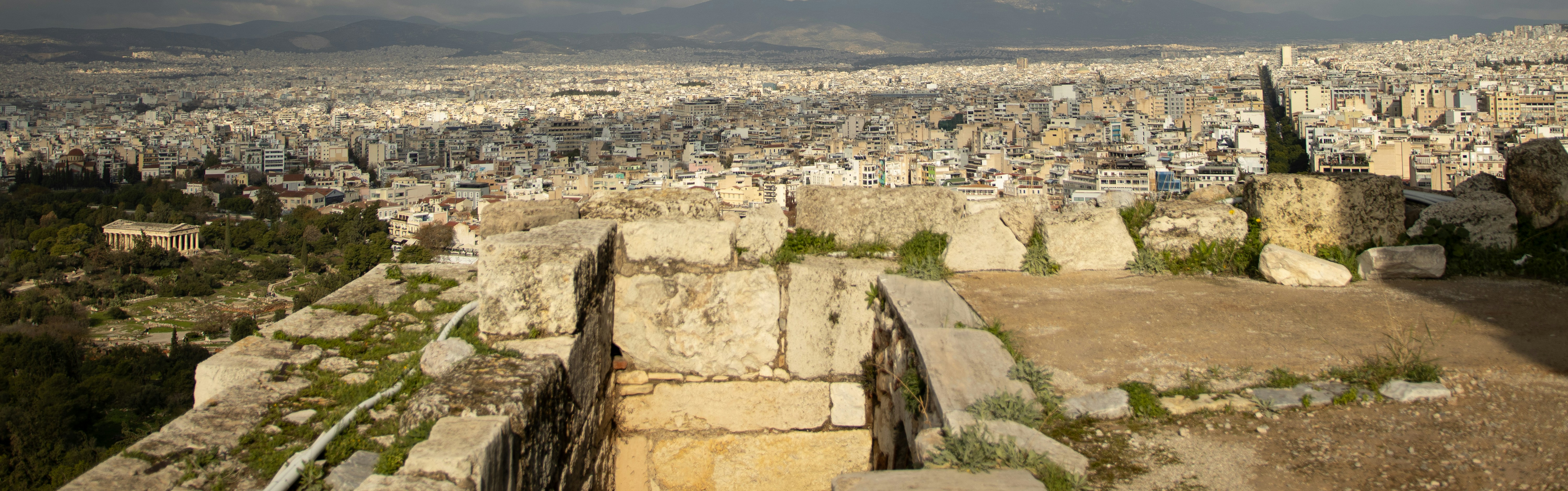 Ancient stone terrace overlooking a sprawling cityscape at dusk
