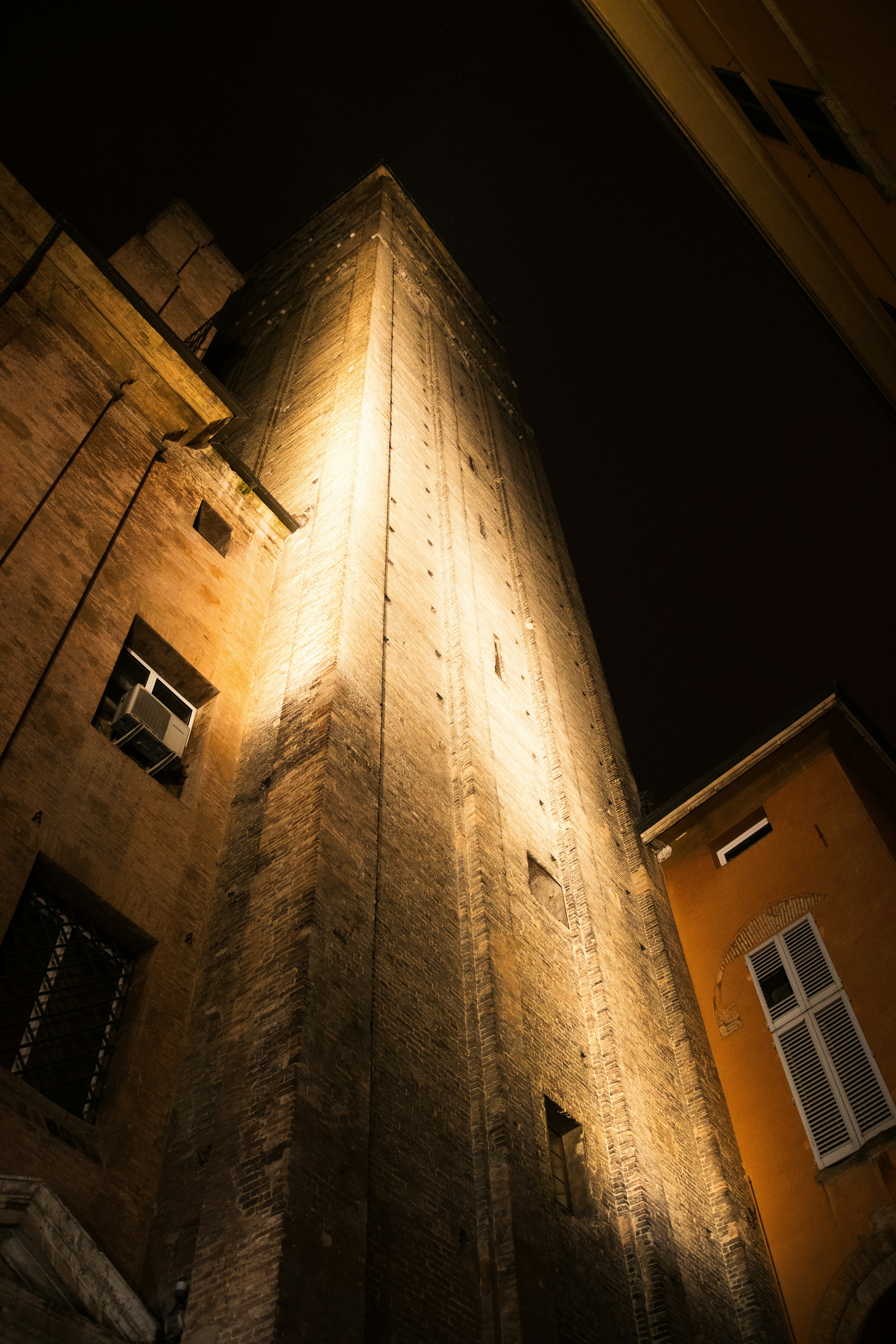 Tall Facade at Night: A Leaning Archive of Warm Light