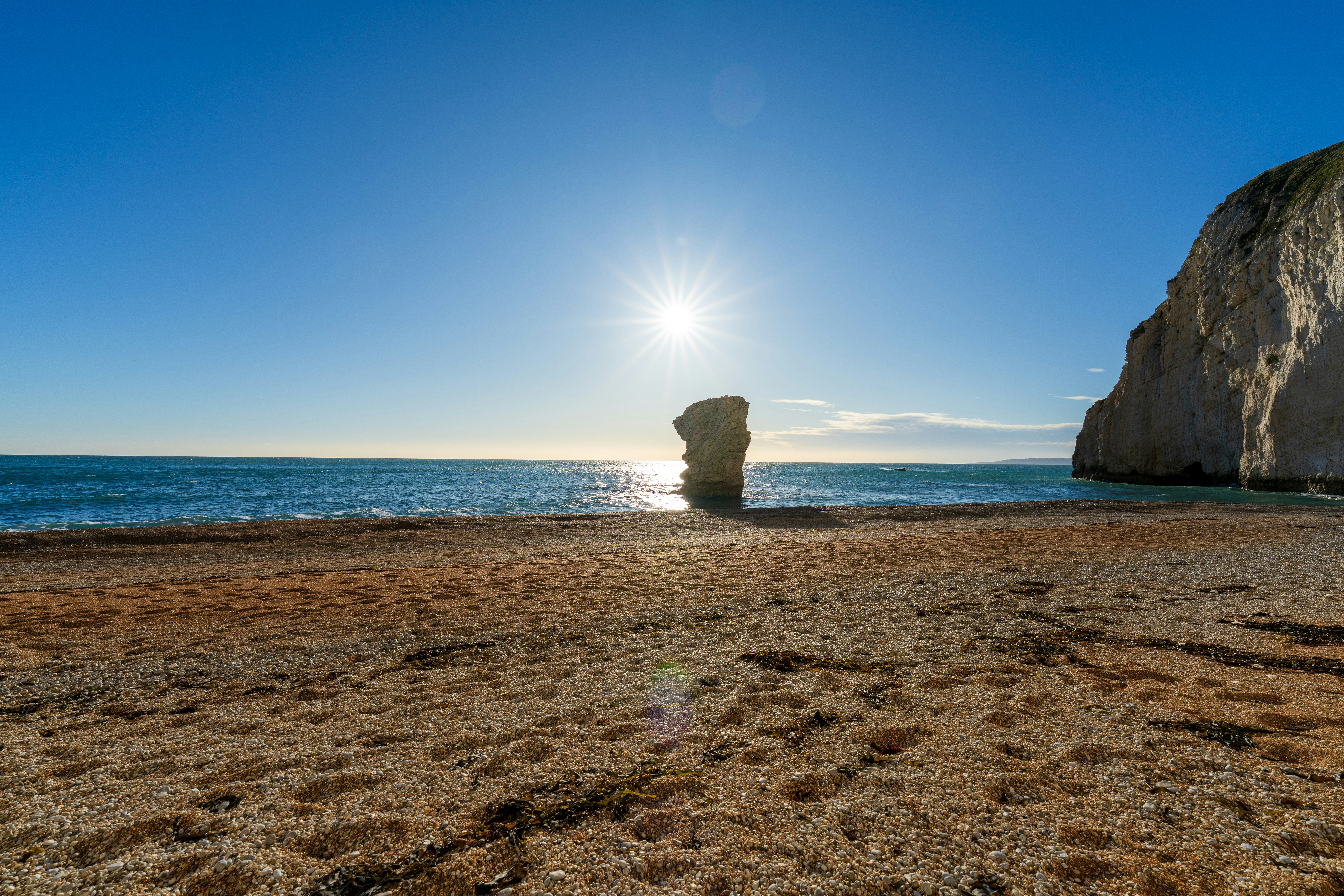 Sunlit Sea Stack at High Tide: A Quiet Coastal Moment